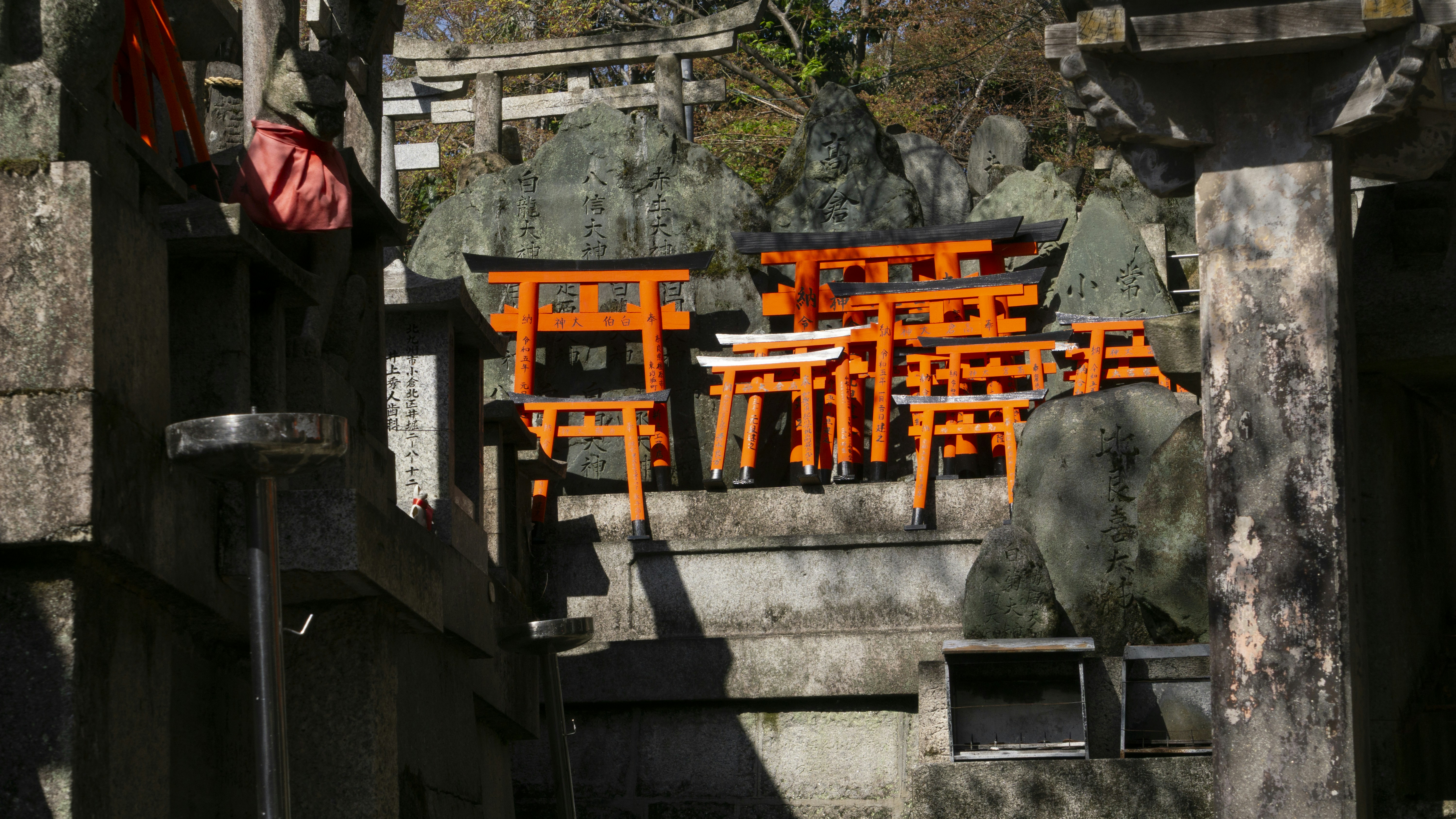 Row of vermilion torii above weathered stone steps