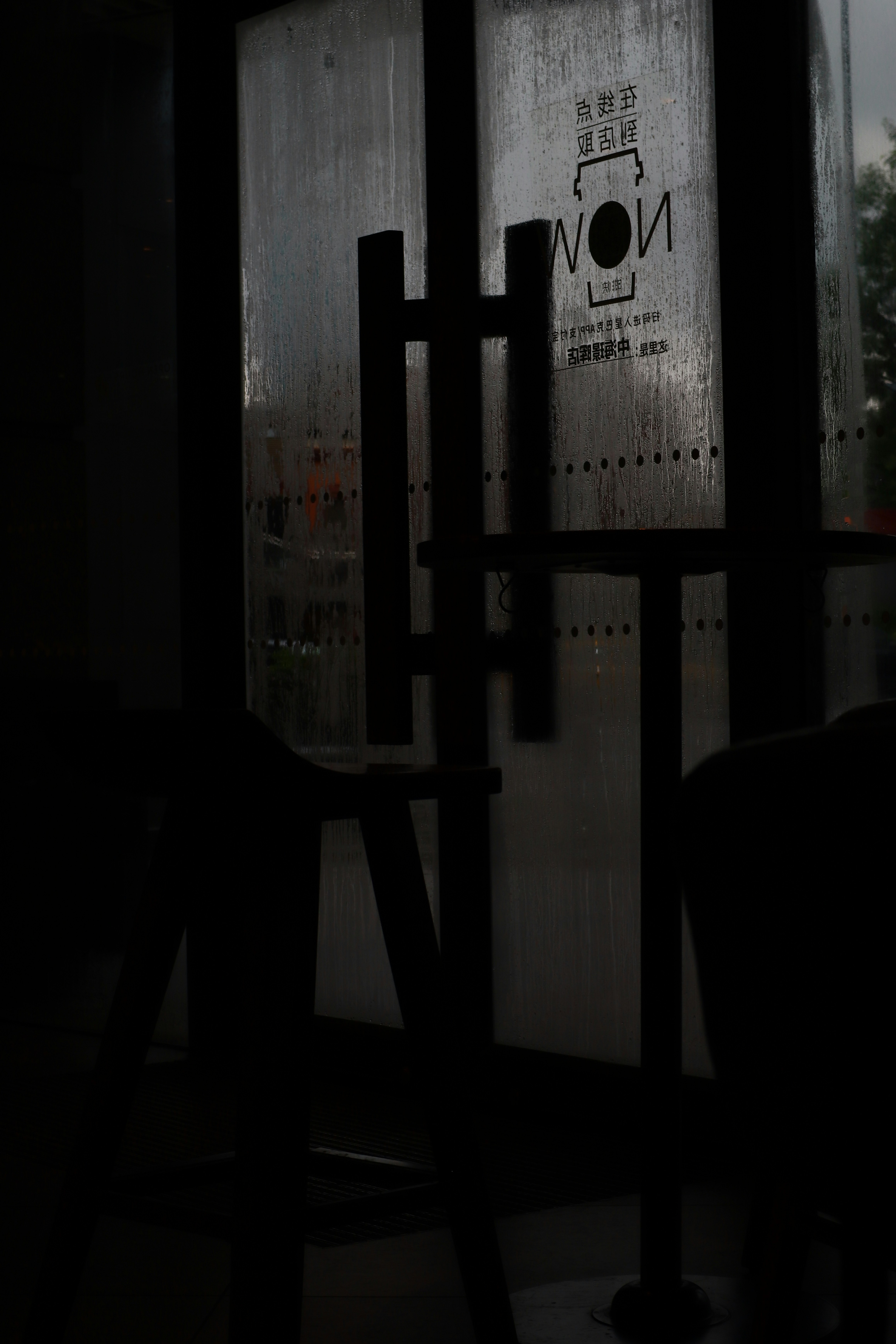Dim cafe silhouette against frosted glass with subtle signage