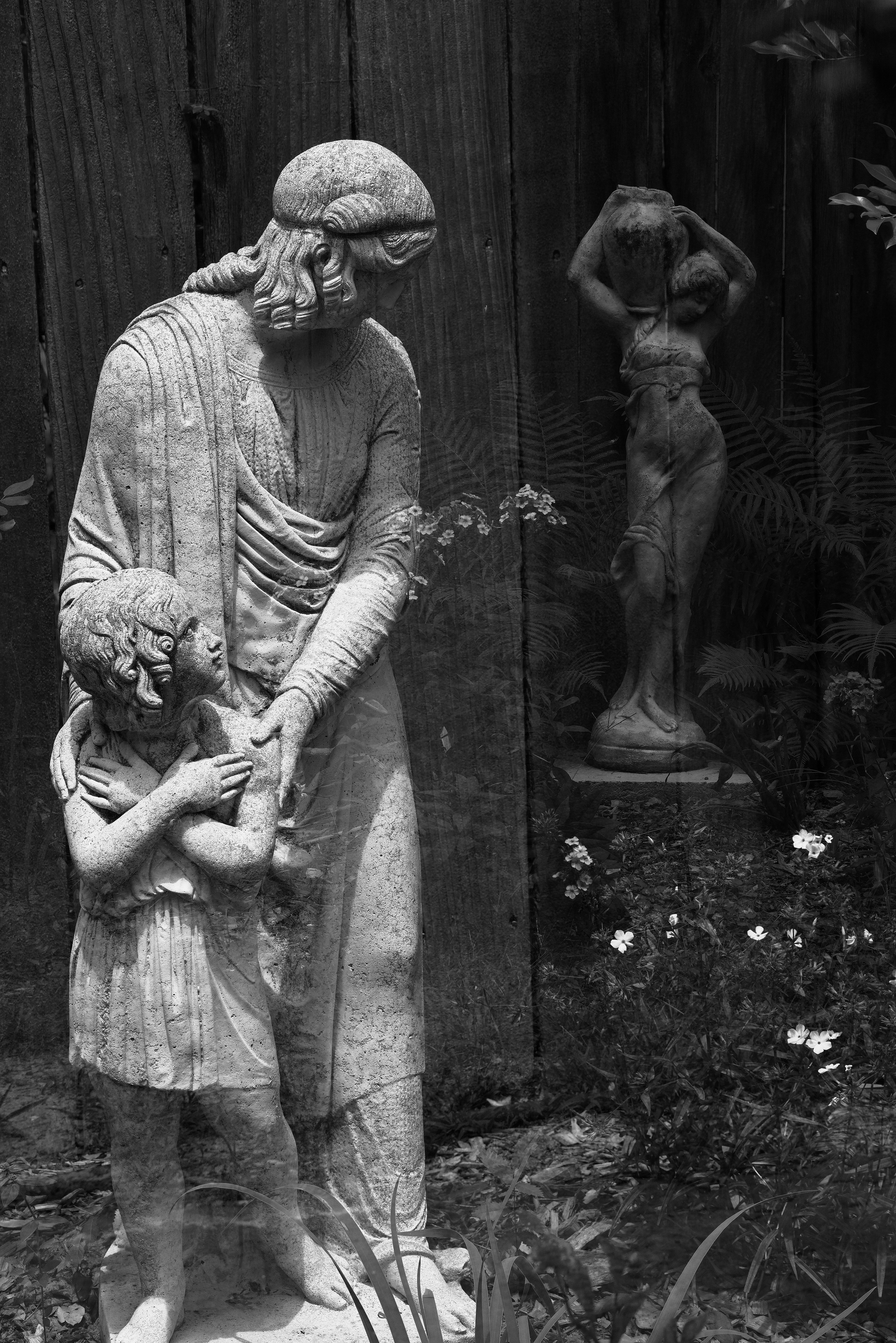 A double exposure photograph of some yard art in my garden. It was shot in camera.