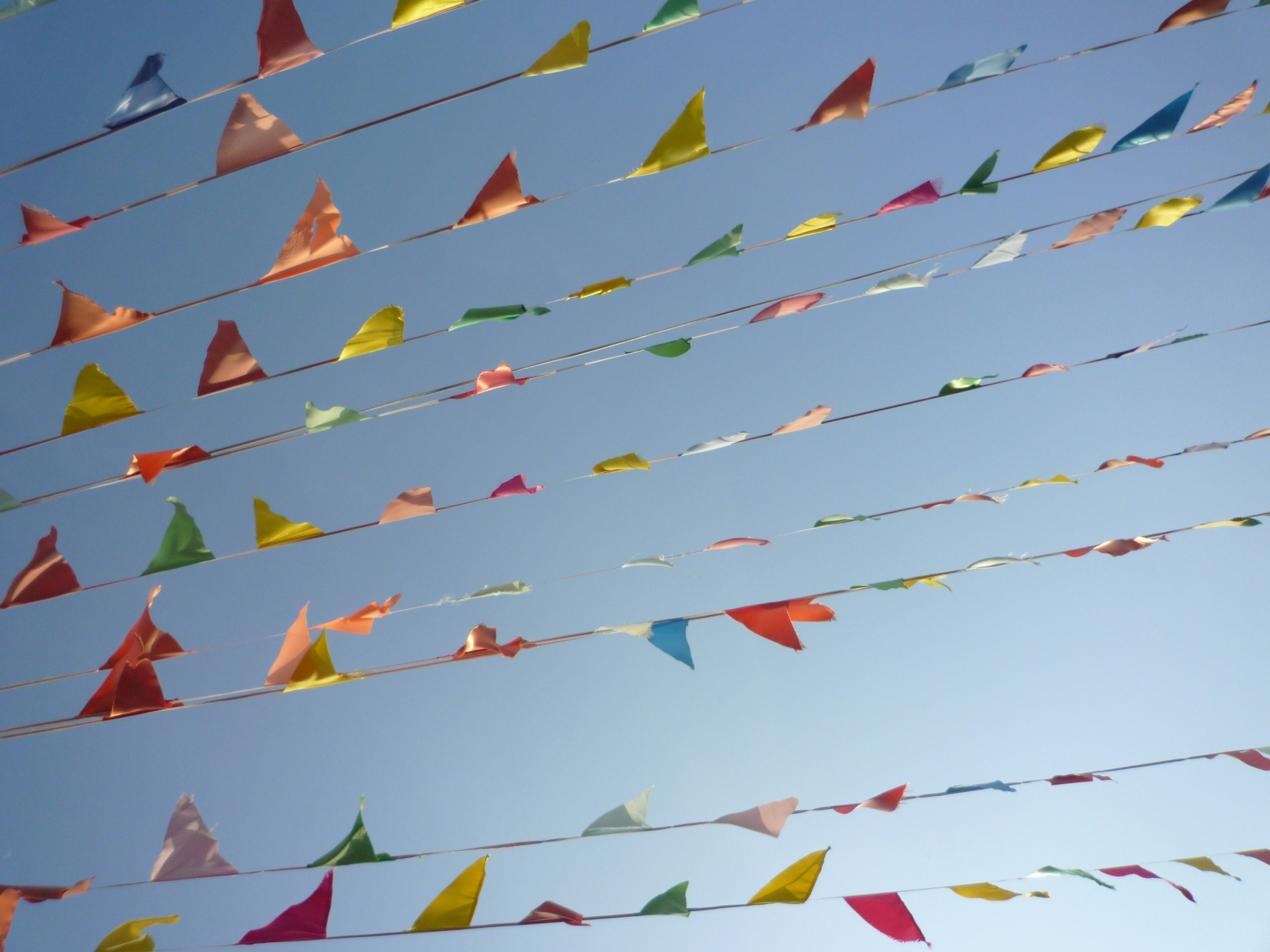 Kite-string Parade: Colorful Flags Against a Clear Sky
