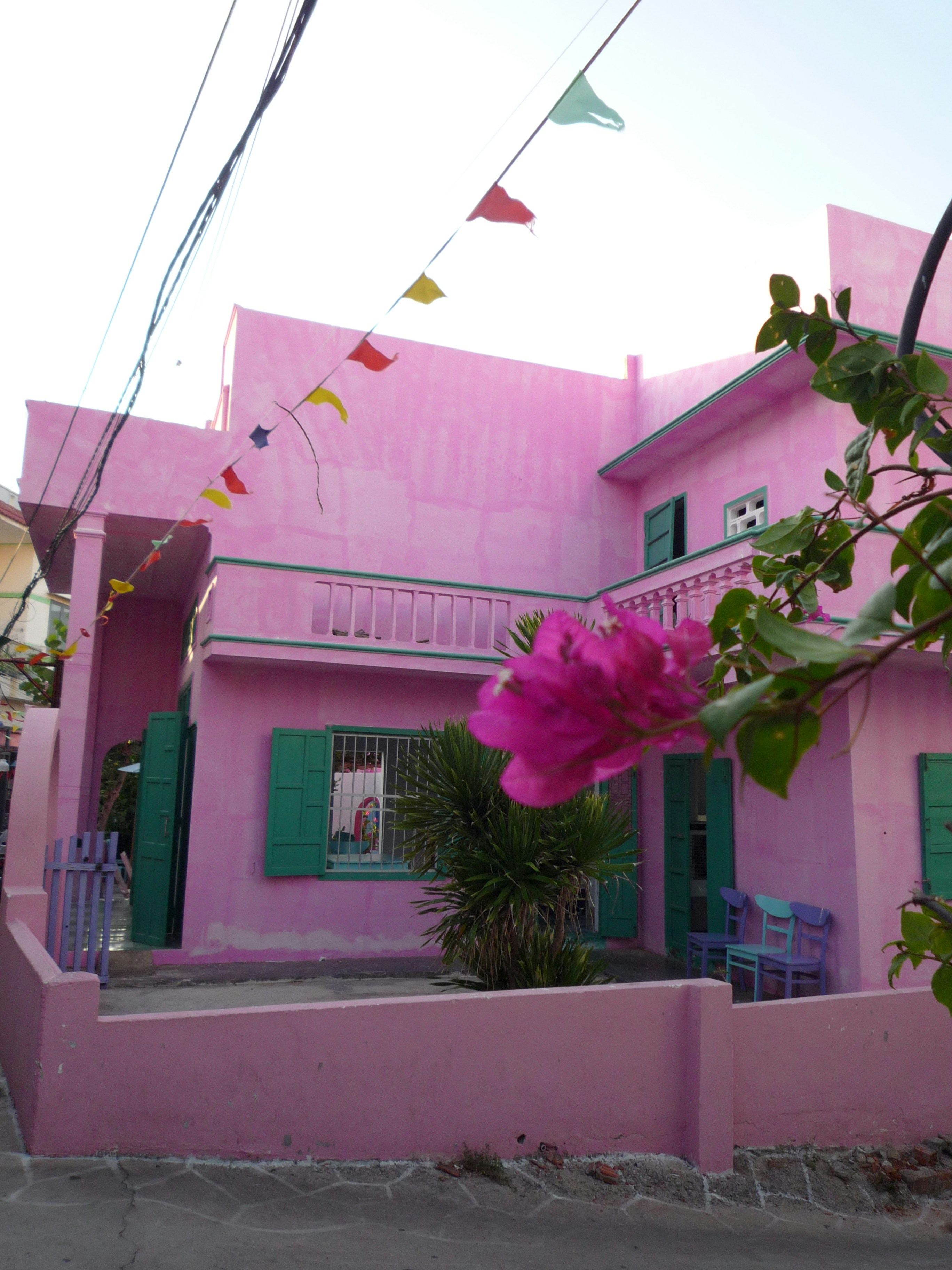 Pink Villa Corner With Green Shutters and Floral Burst