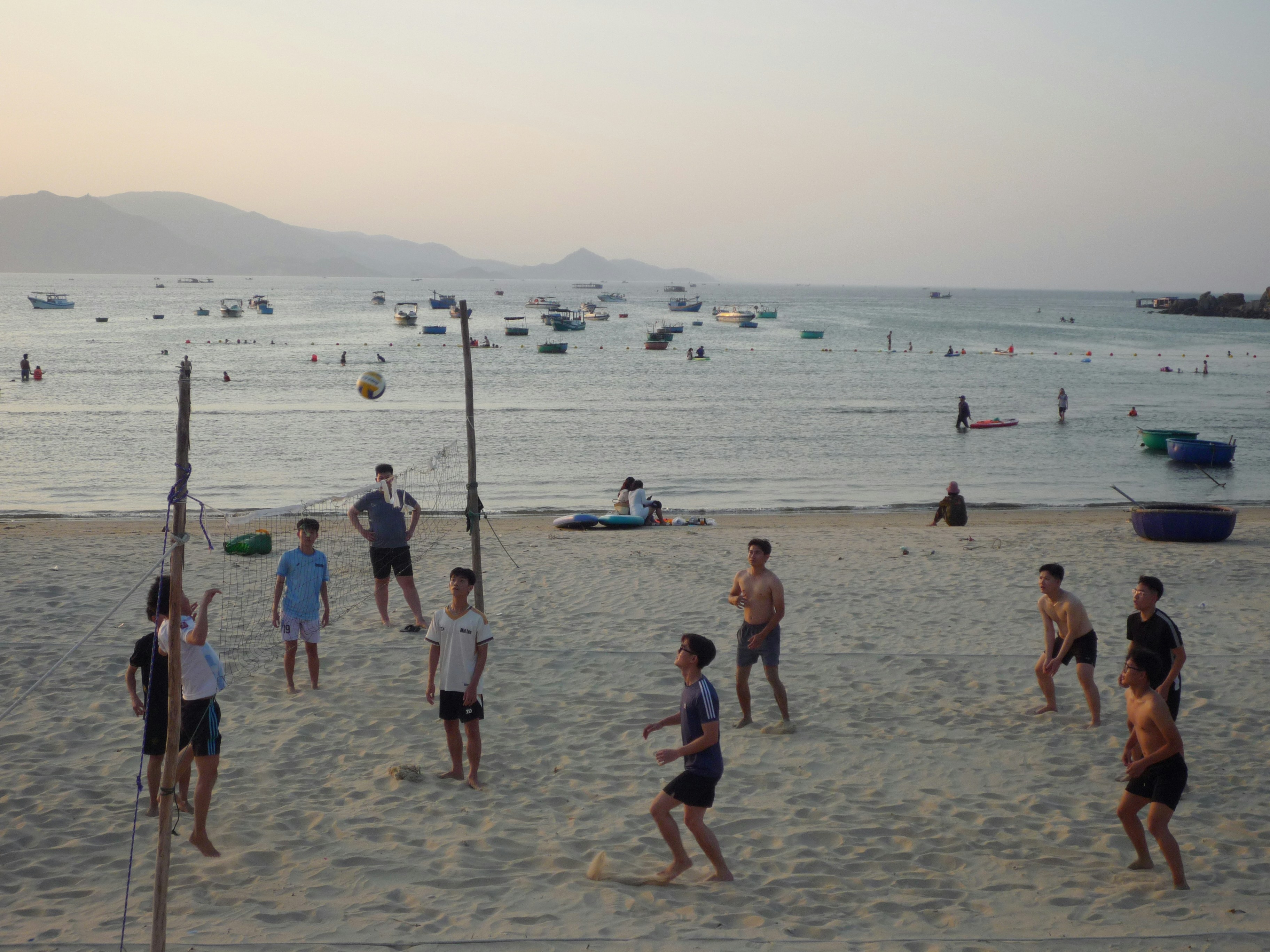 Volleyball on the Dune: Beachgoers Rally Along a Calm Shore at Dusk