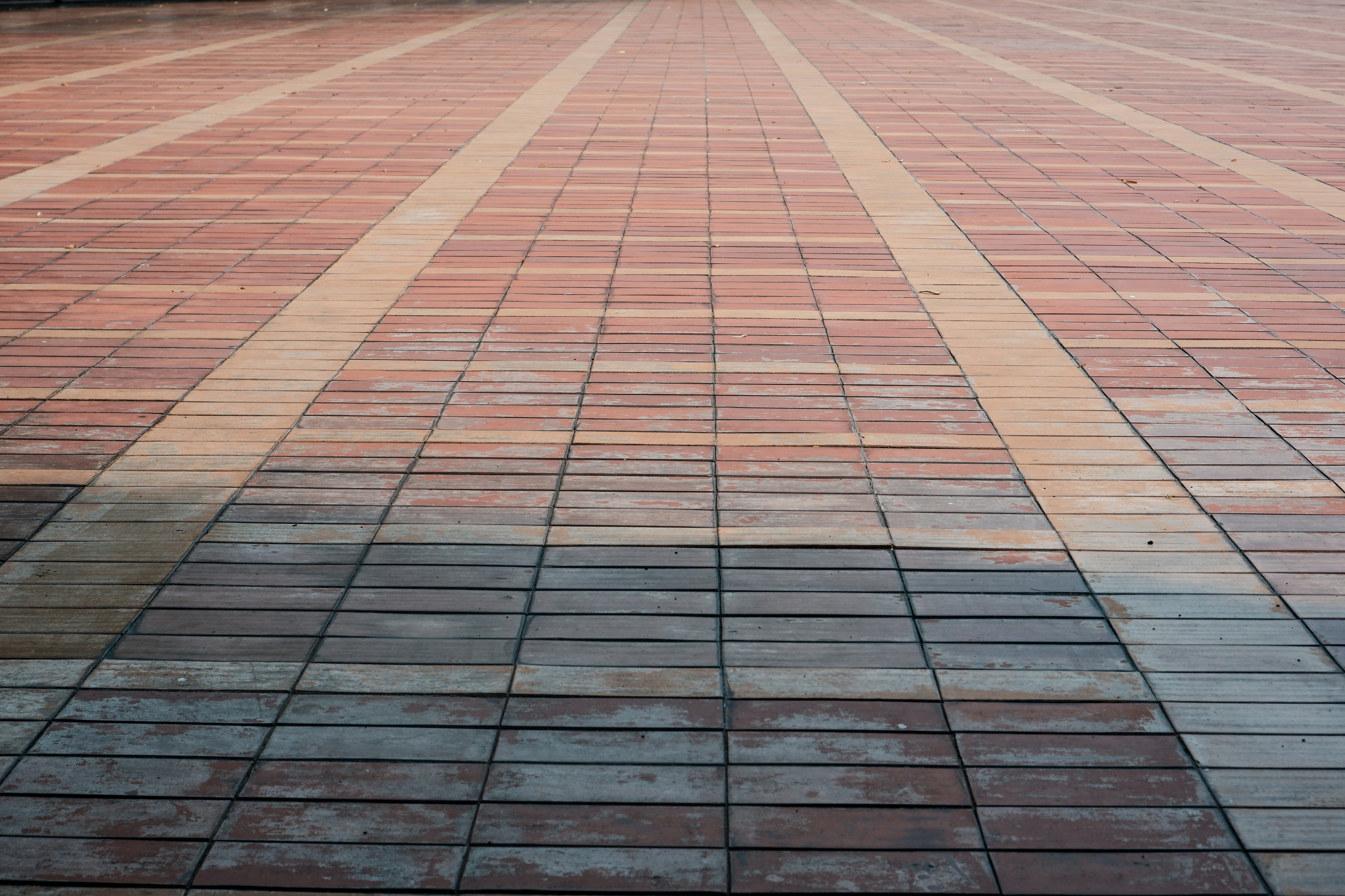 Red and gray patterned brick pavement with linear design.