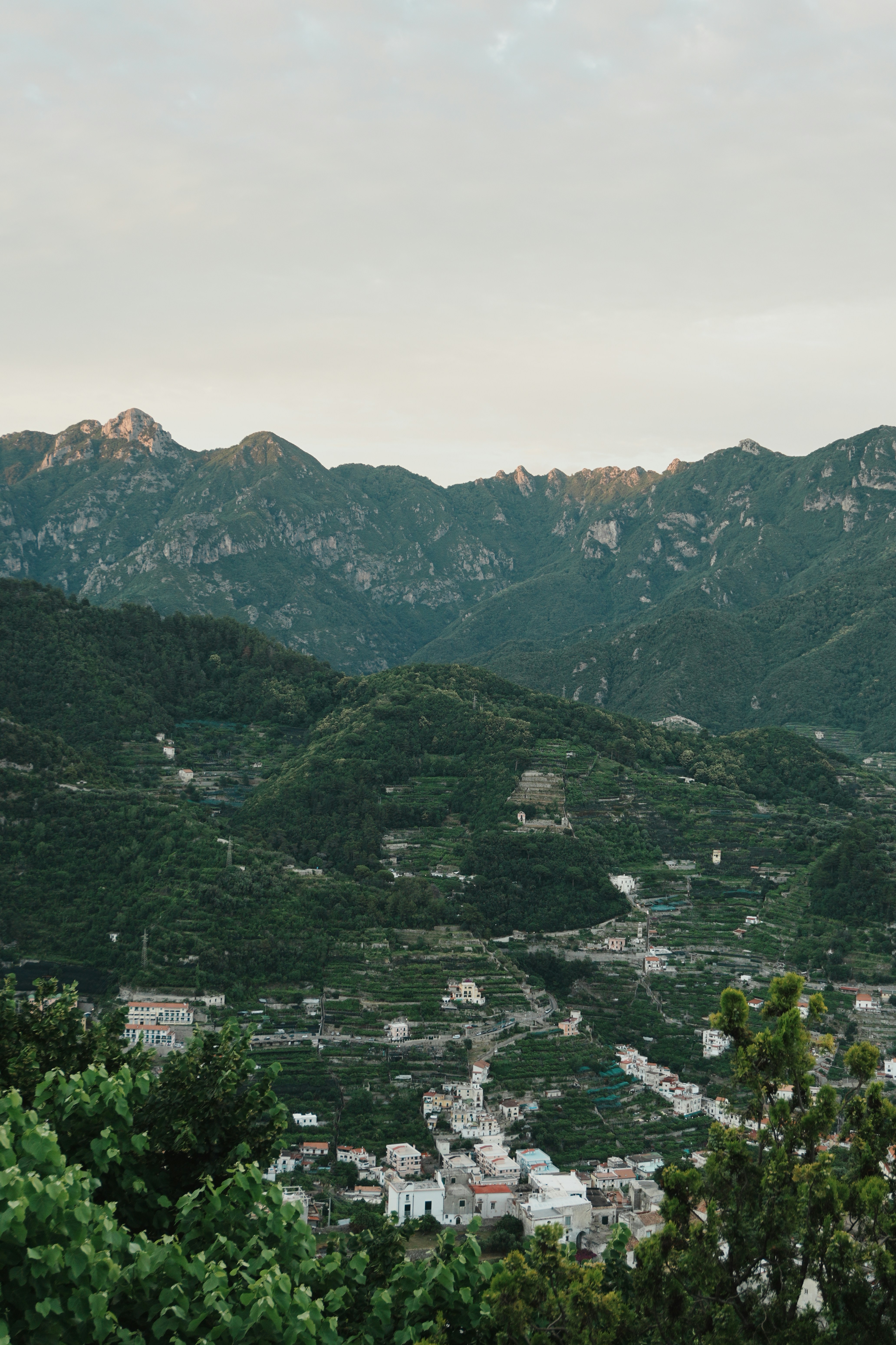 Terraced Valleys beneath a Distant Alpine Ridge at Dusk
