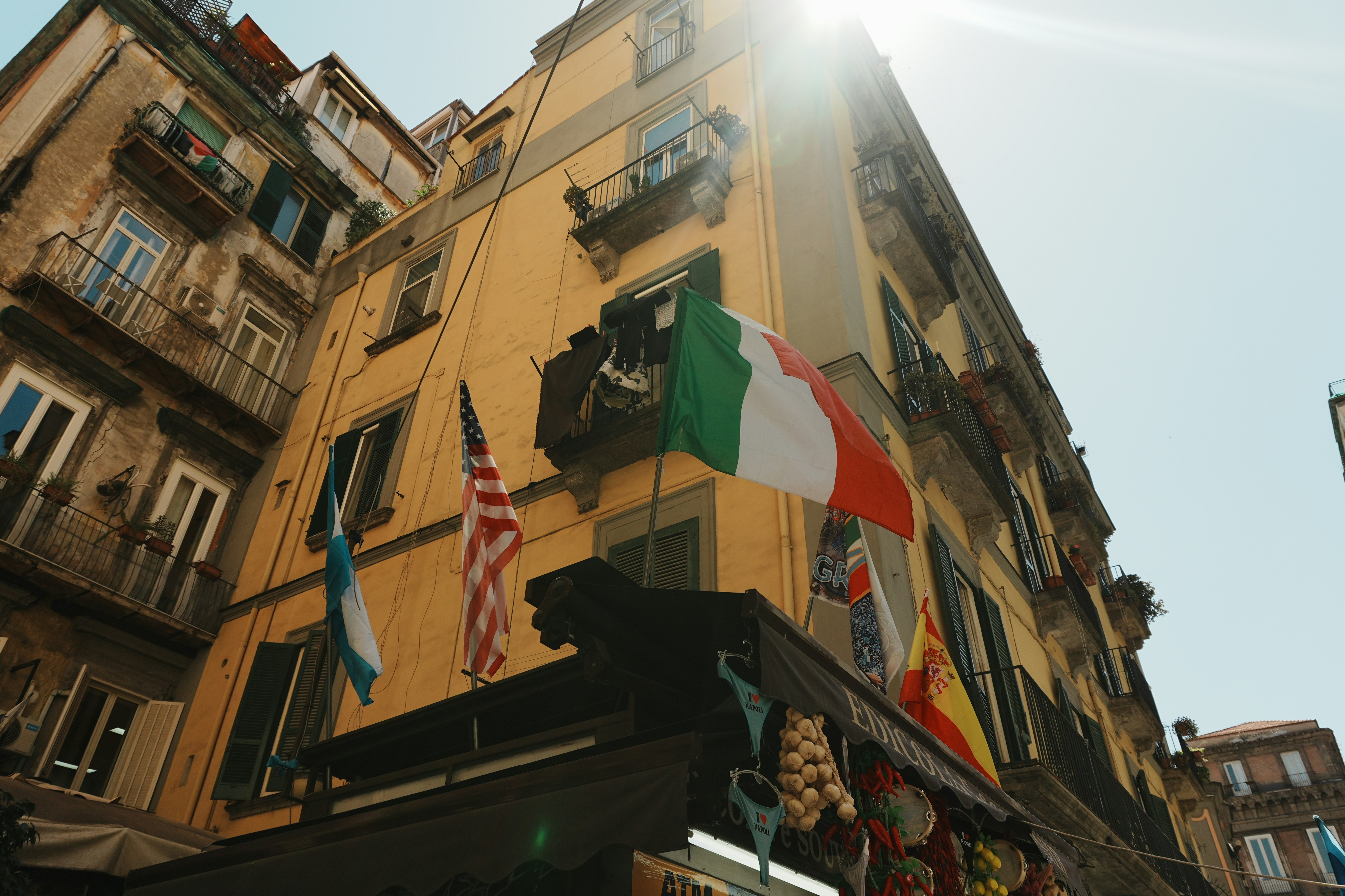 Sunny Street Flags: A European Balcony Scene Framed by Warm Facades