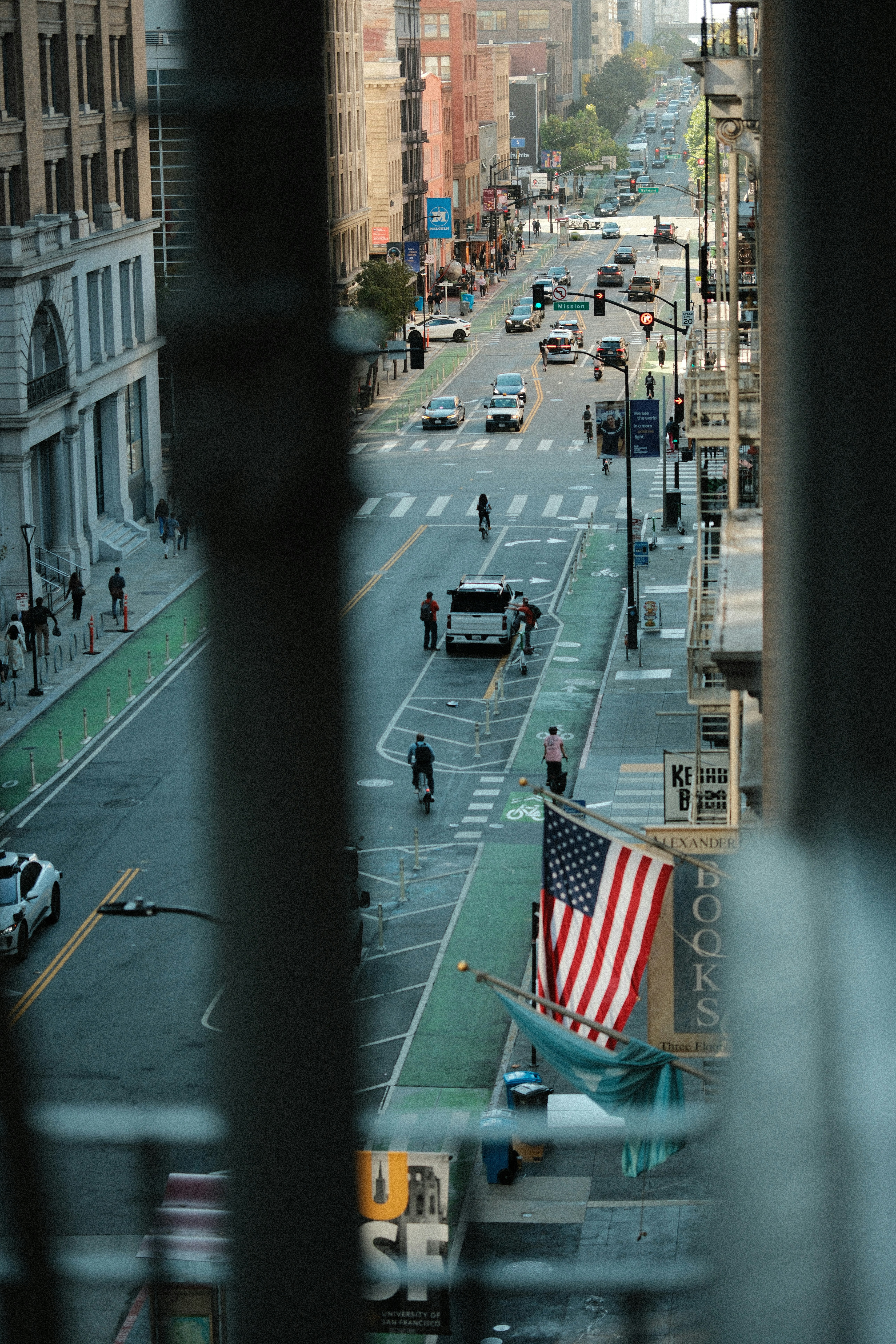 Street Corridor: a city scene framed between iron bars with pedestrians and a fluttering American flag