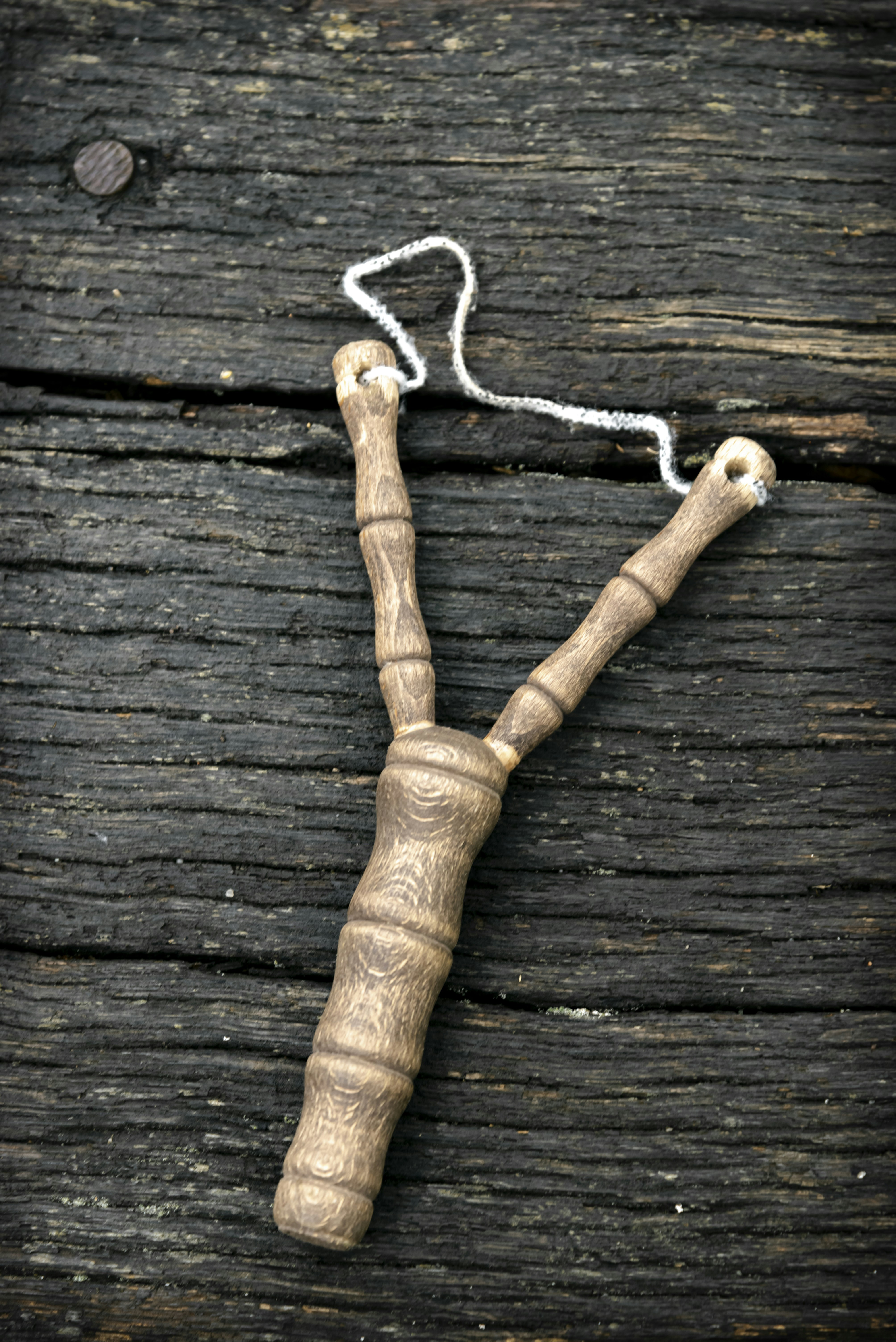 Stringed Hand: A carved wooden figure with a rustic string on weathered boards