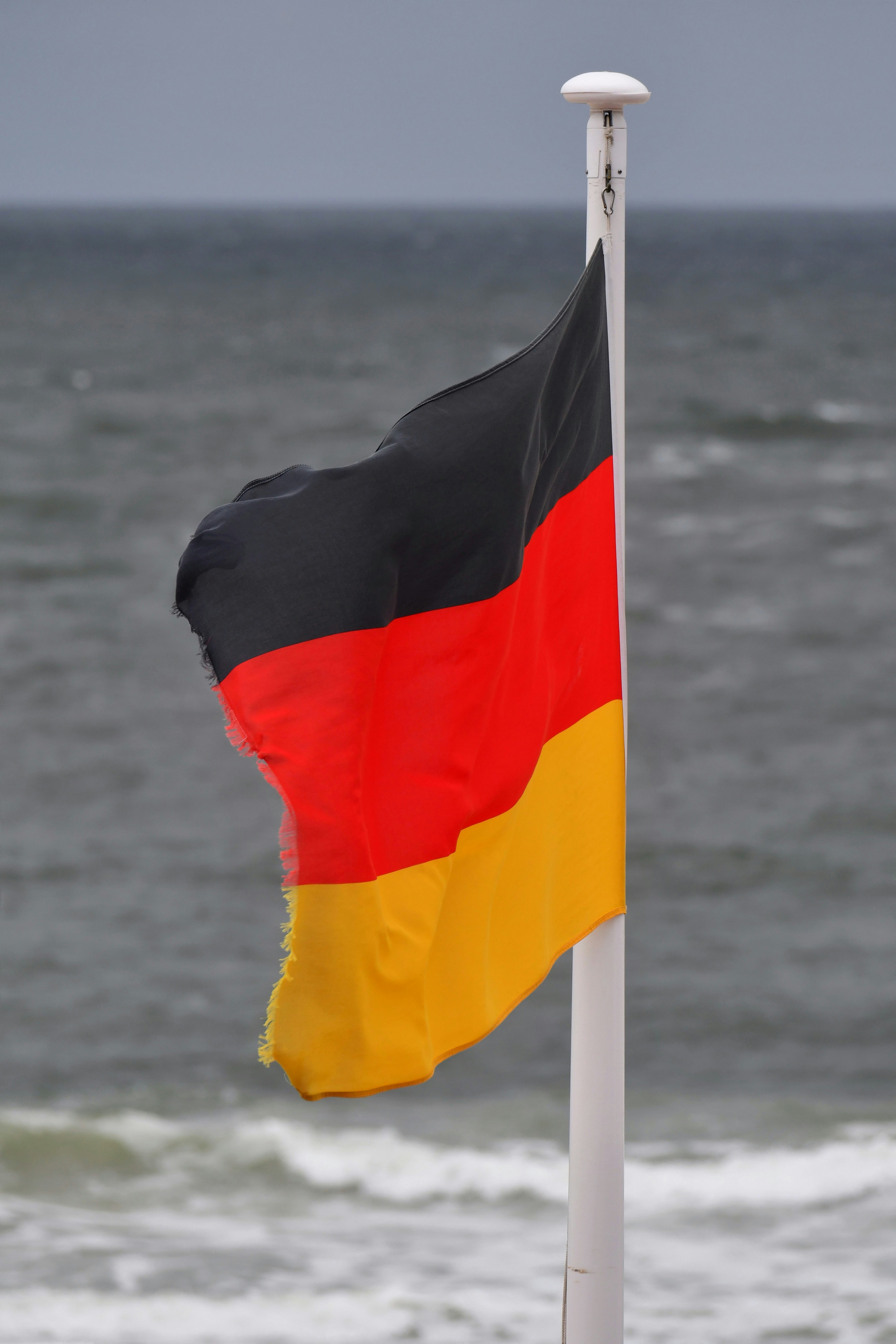 Flag at Sea: A Red-Black-Gold Banner Framing the Ocean