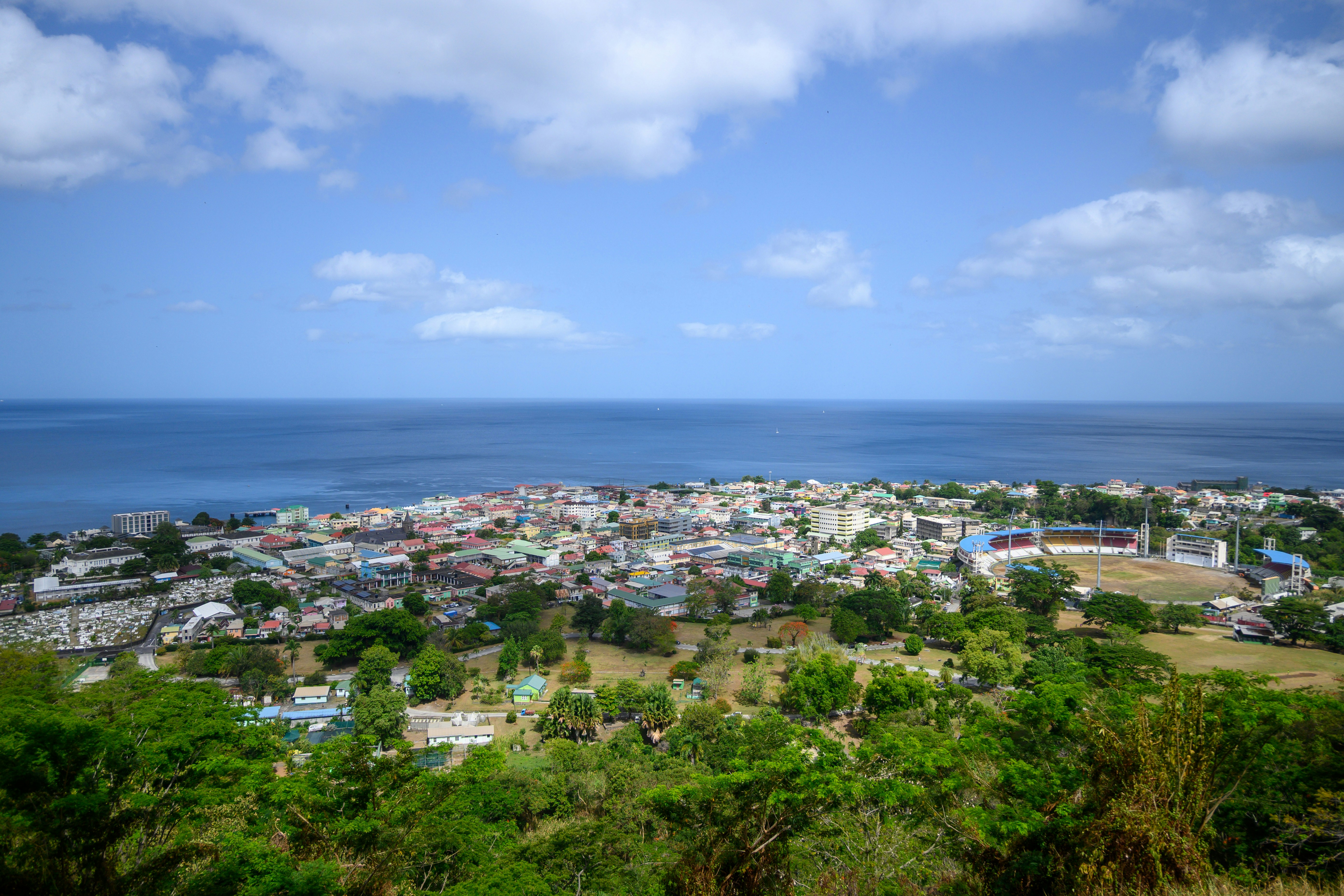 Coastal town unfurling along the shoreline beneath a bright sky