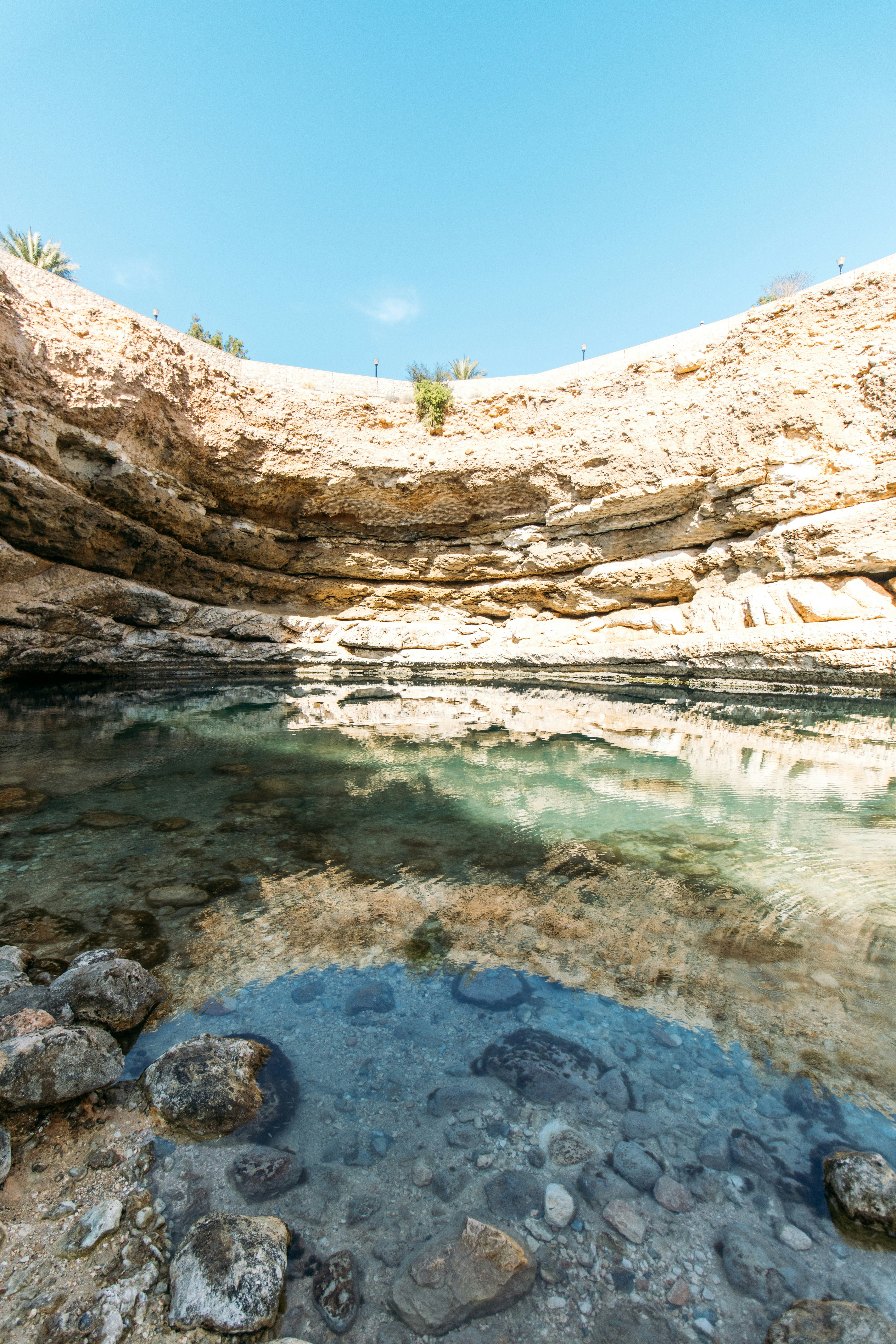 Stone Rim Reflections: An Aegean-like Cenote Under a Clear Sky