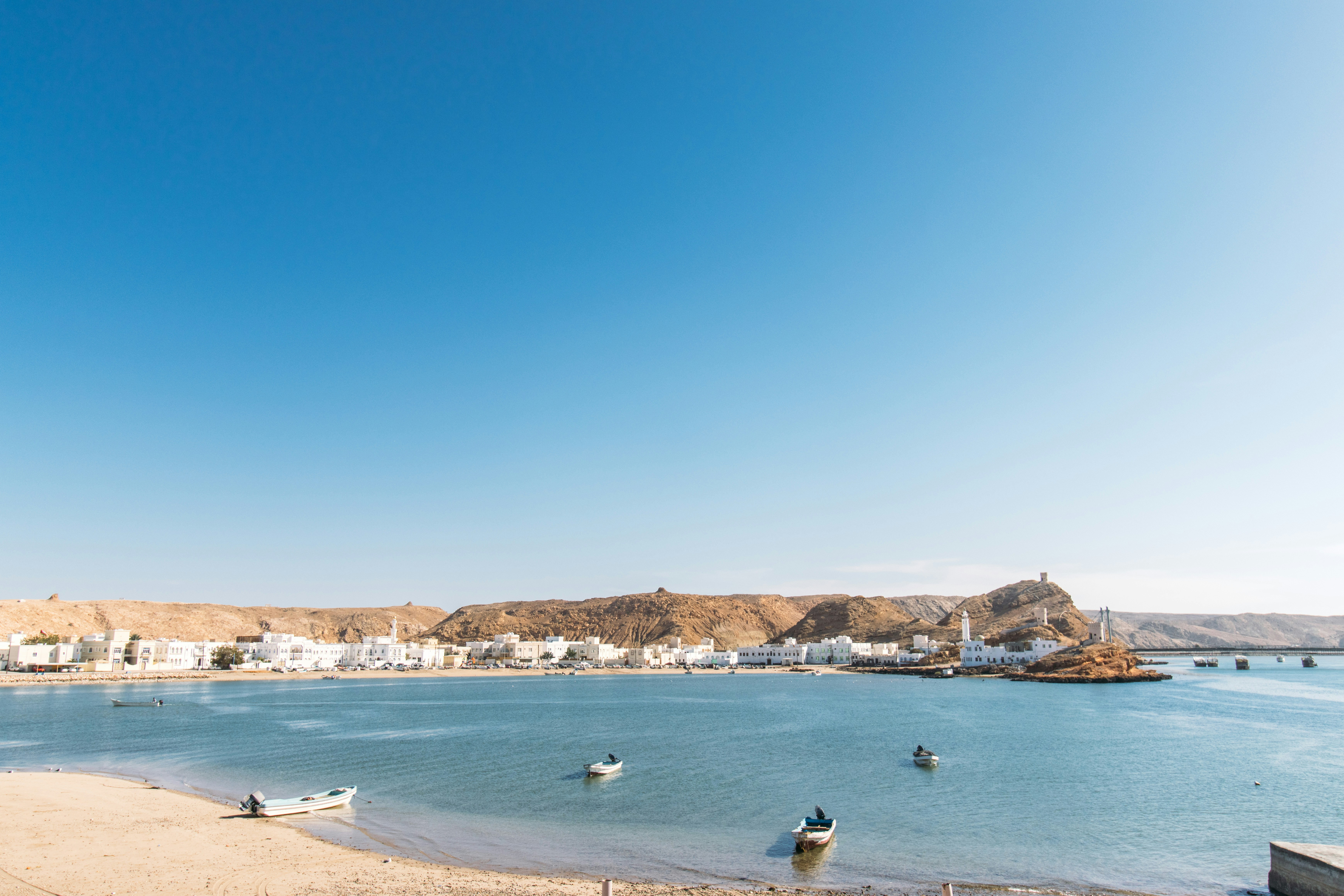 Harbor Village at Dusk: A Quiet Line of Boats and Clay-colored Cliffs
