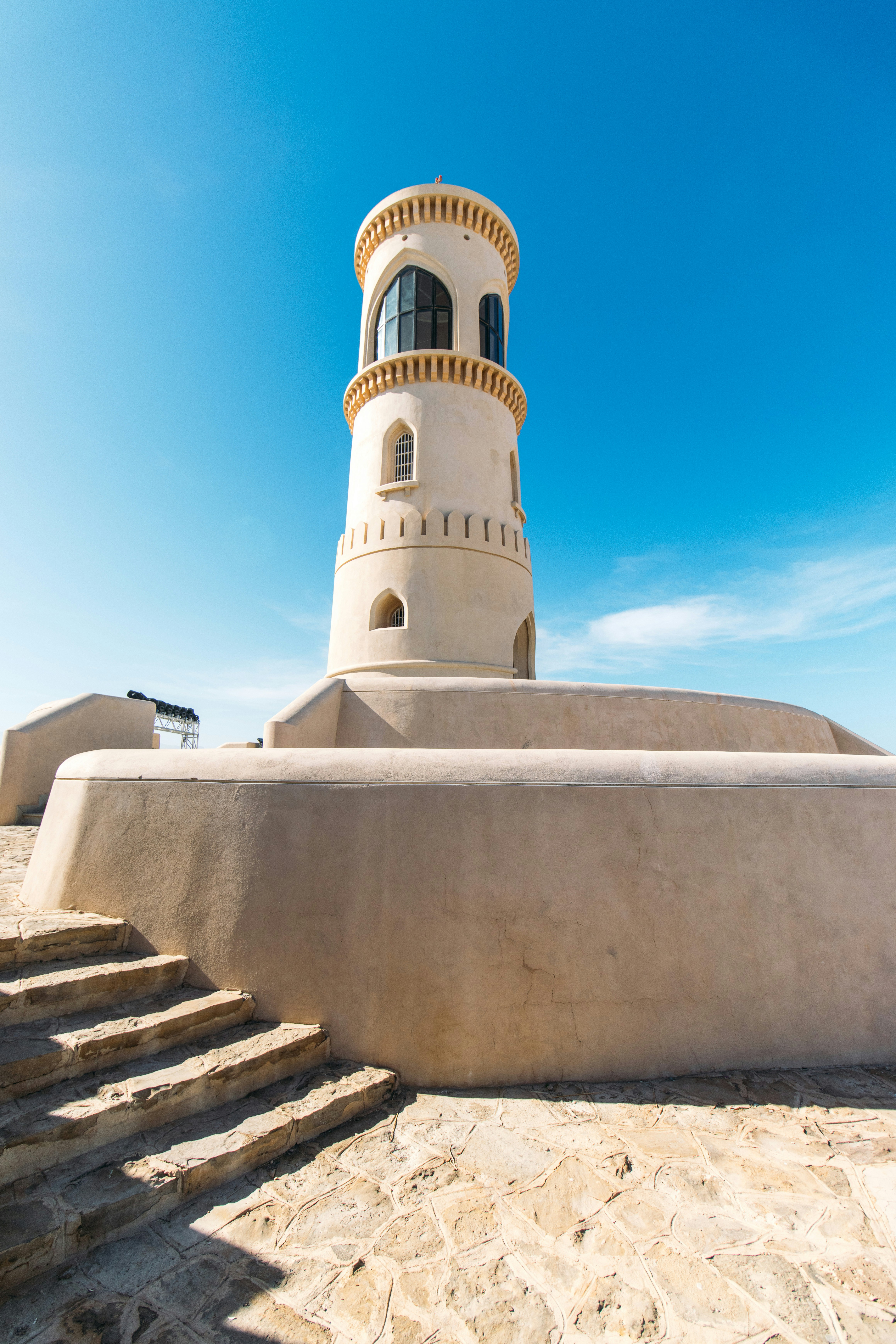 Sunlit Sentinel: A White Lighthouse Reaching Toward the Sky