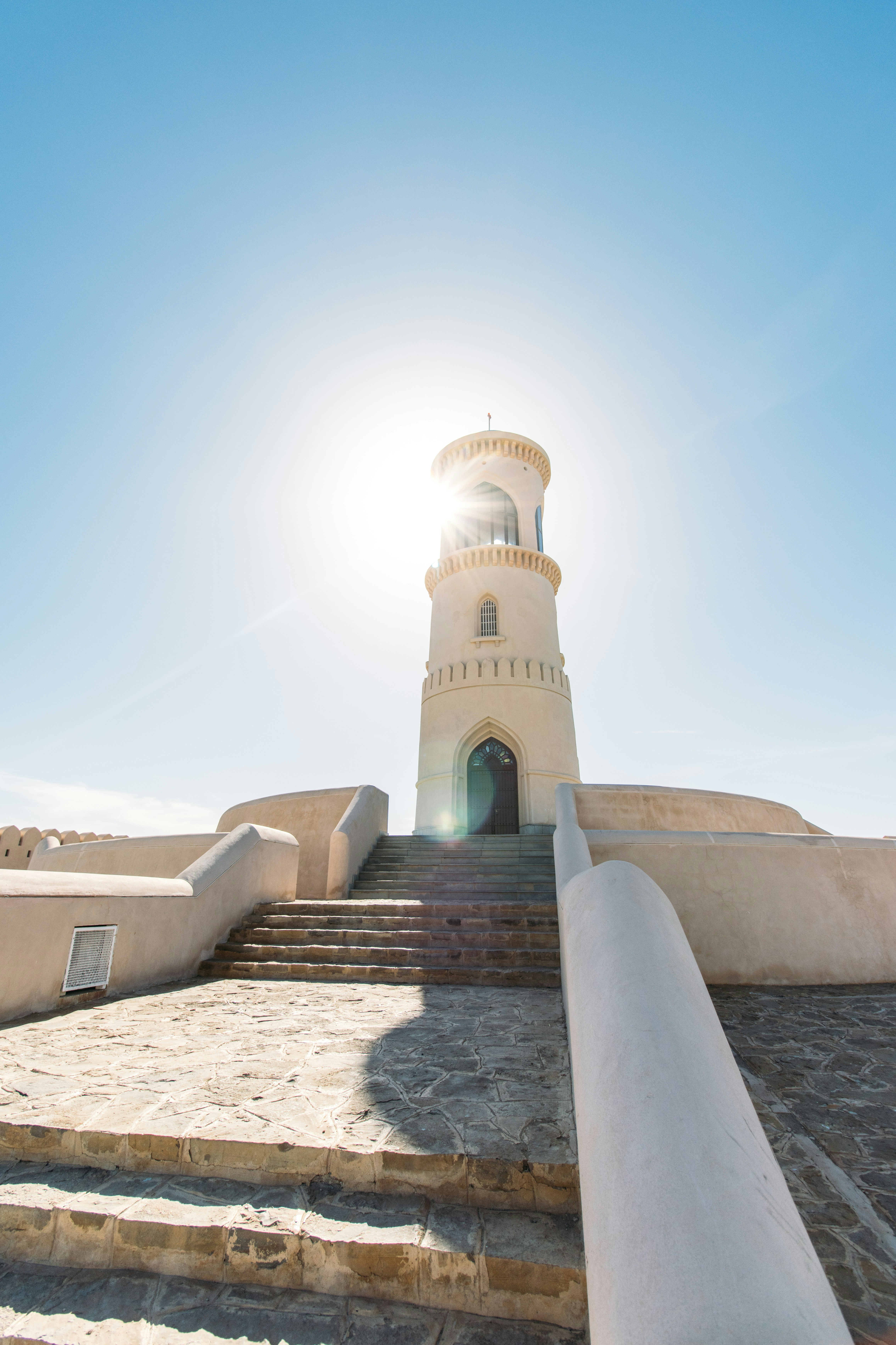 Sunlit Lighthouse Rising from Stone Steps