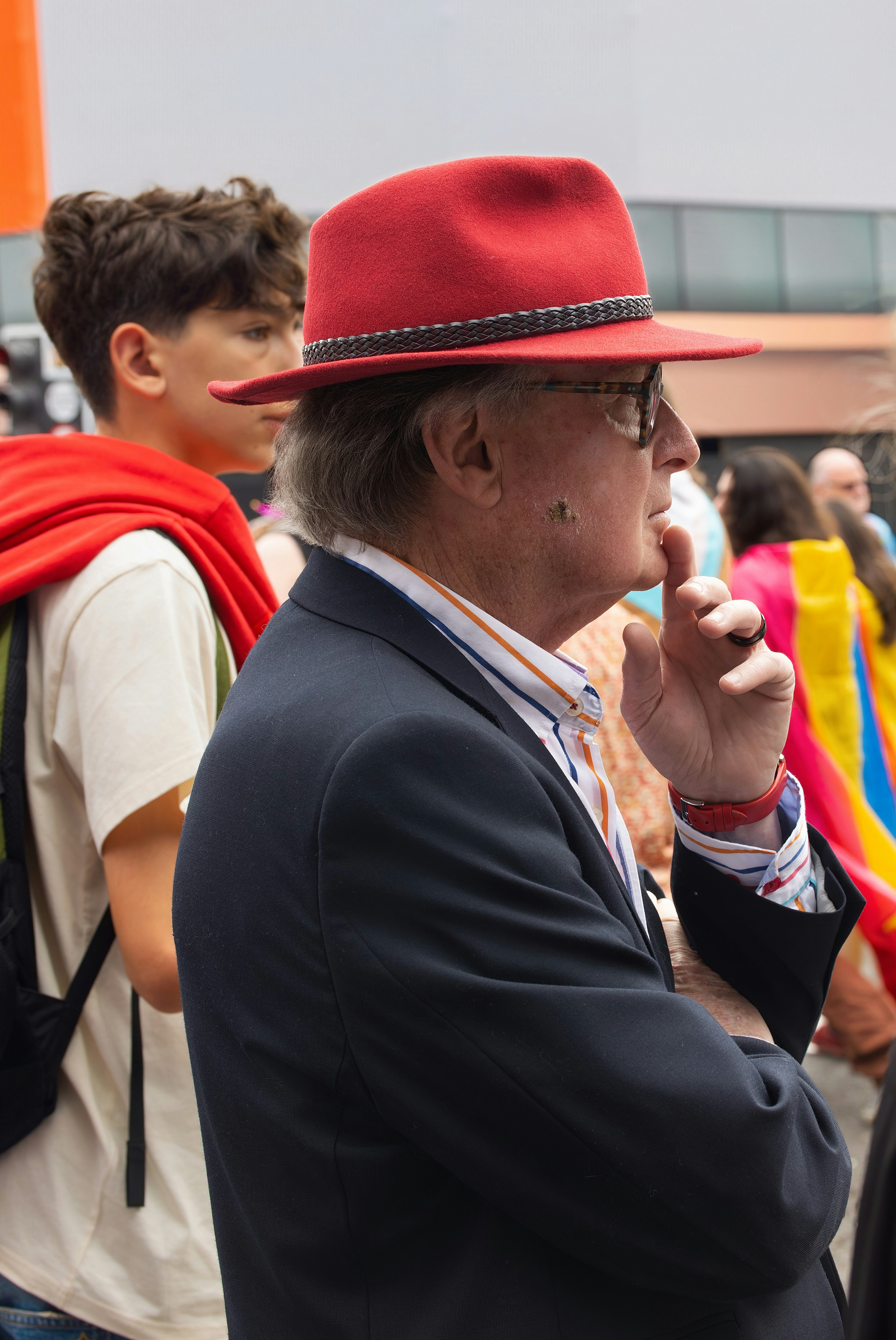 Red Hat Contemplation at a Colorful Crowd