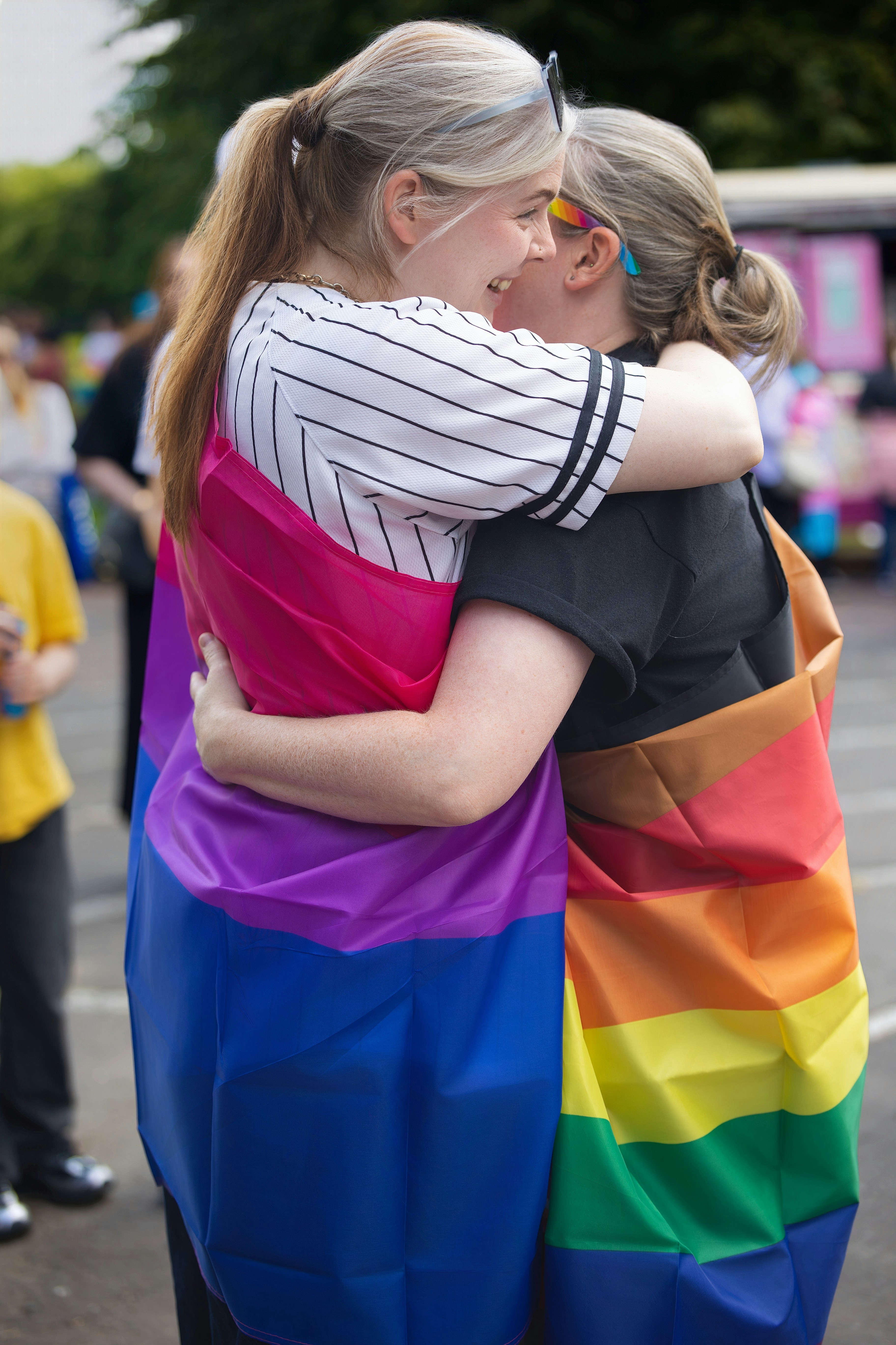 Two friends share a celebratory hug at Pride parade