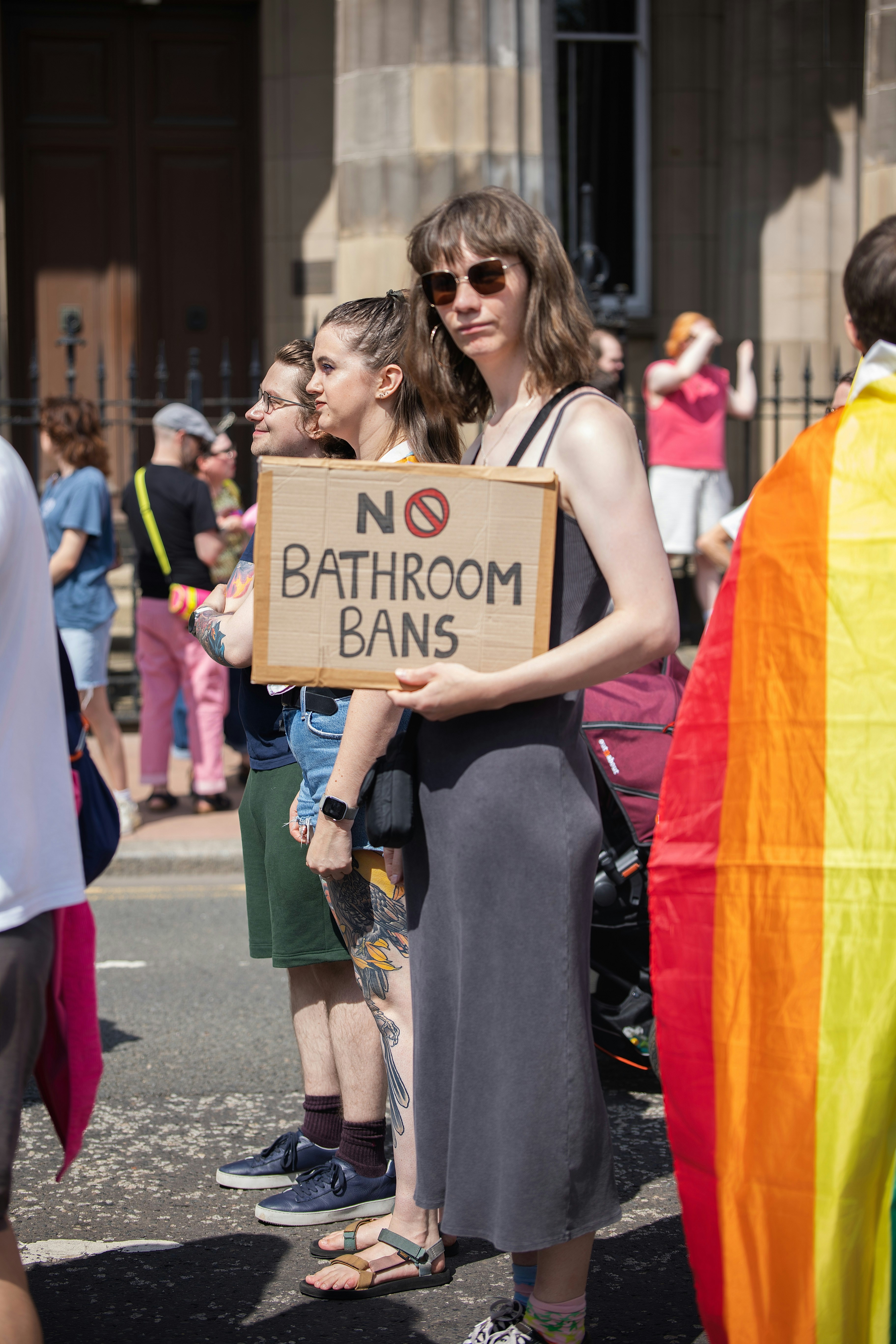 Protester with cardboard sign at a Pride march stands front-and-center