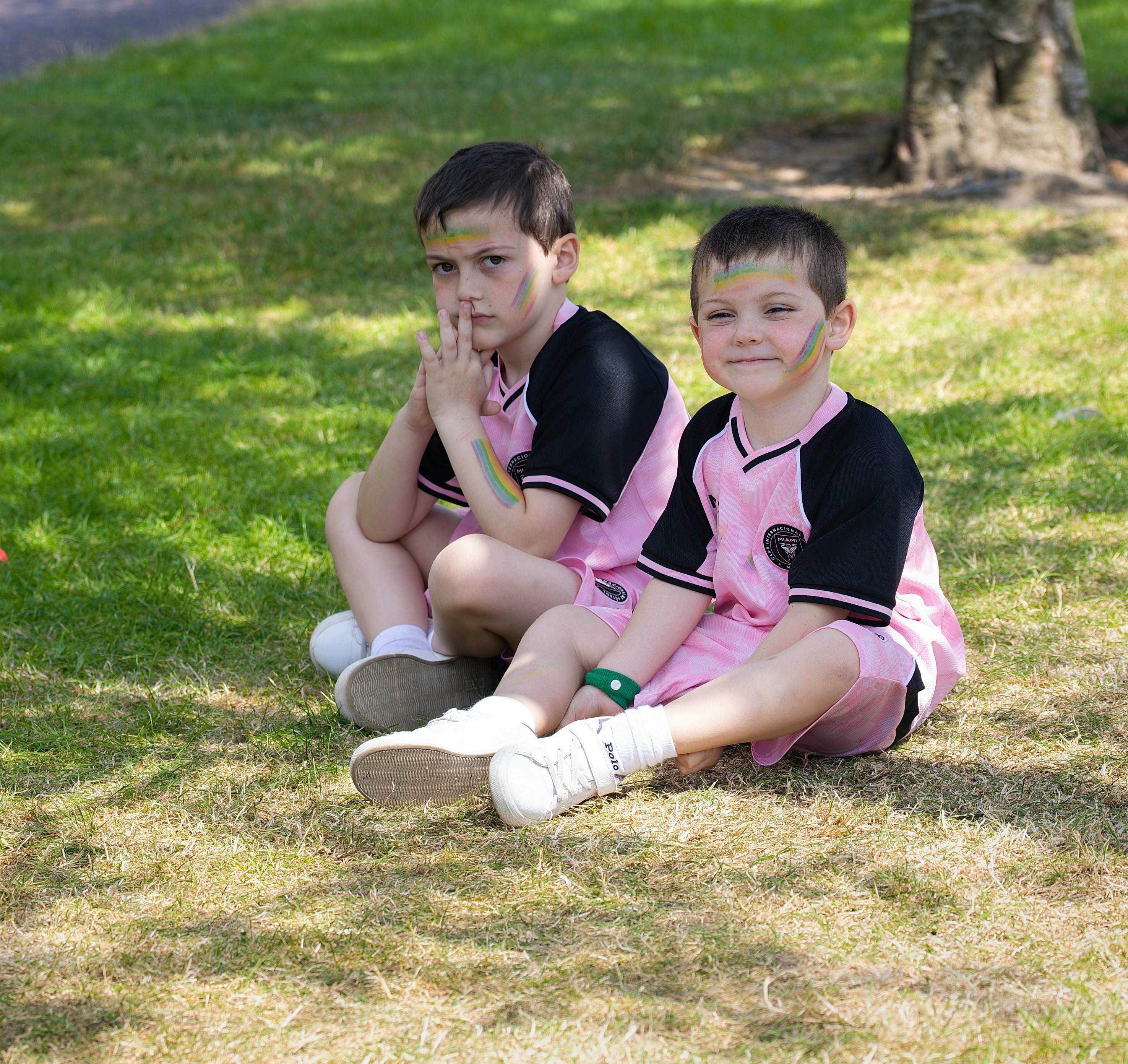 Twin smiles in park sapling shade