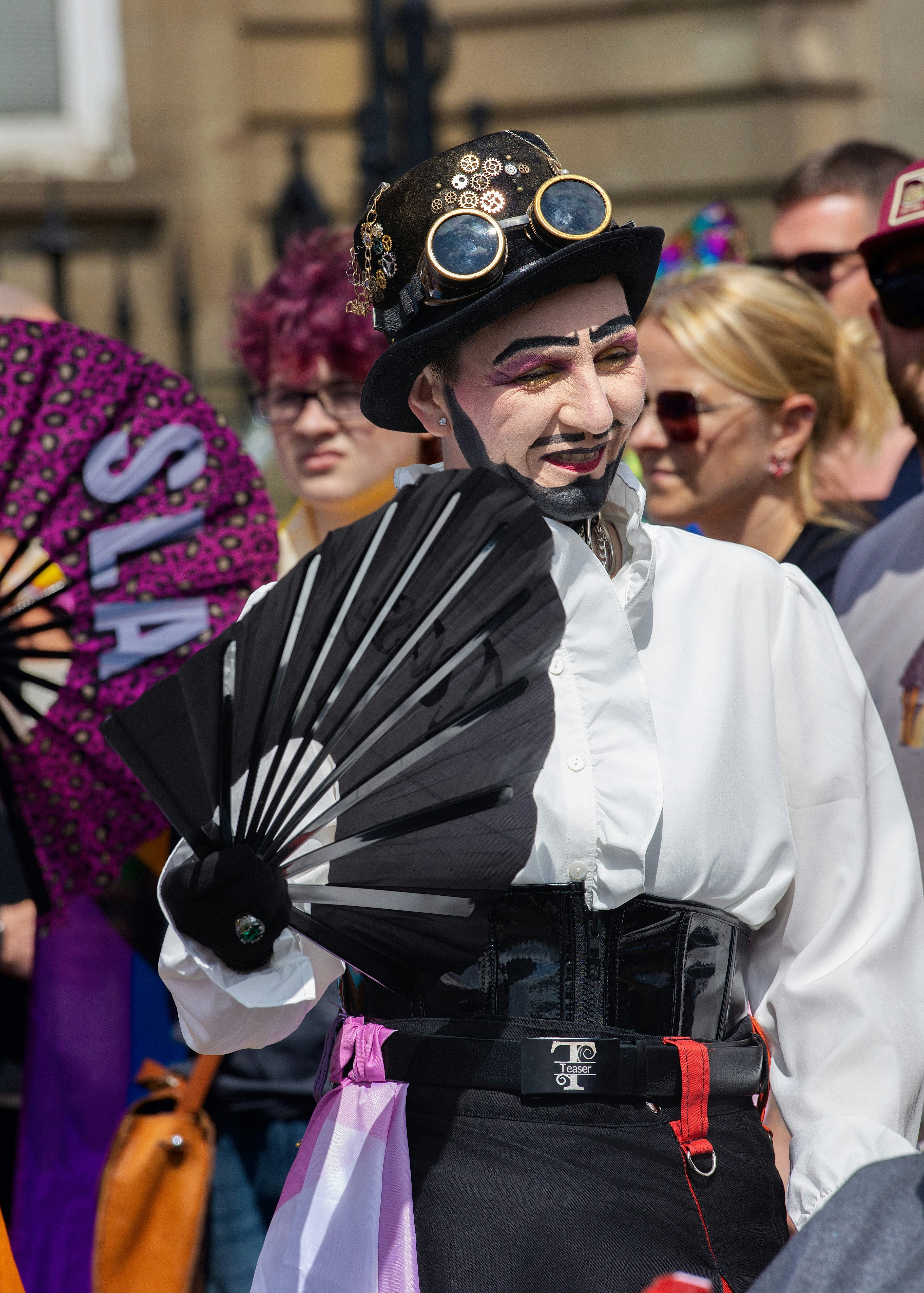 Steampunk Soirée: A Performer in White and Black Corset Nods to the Crowd