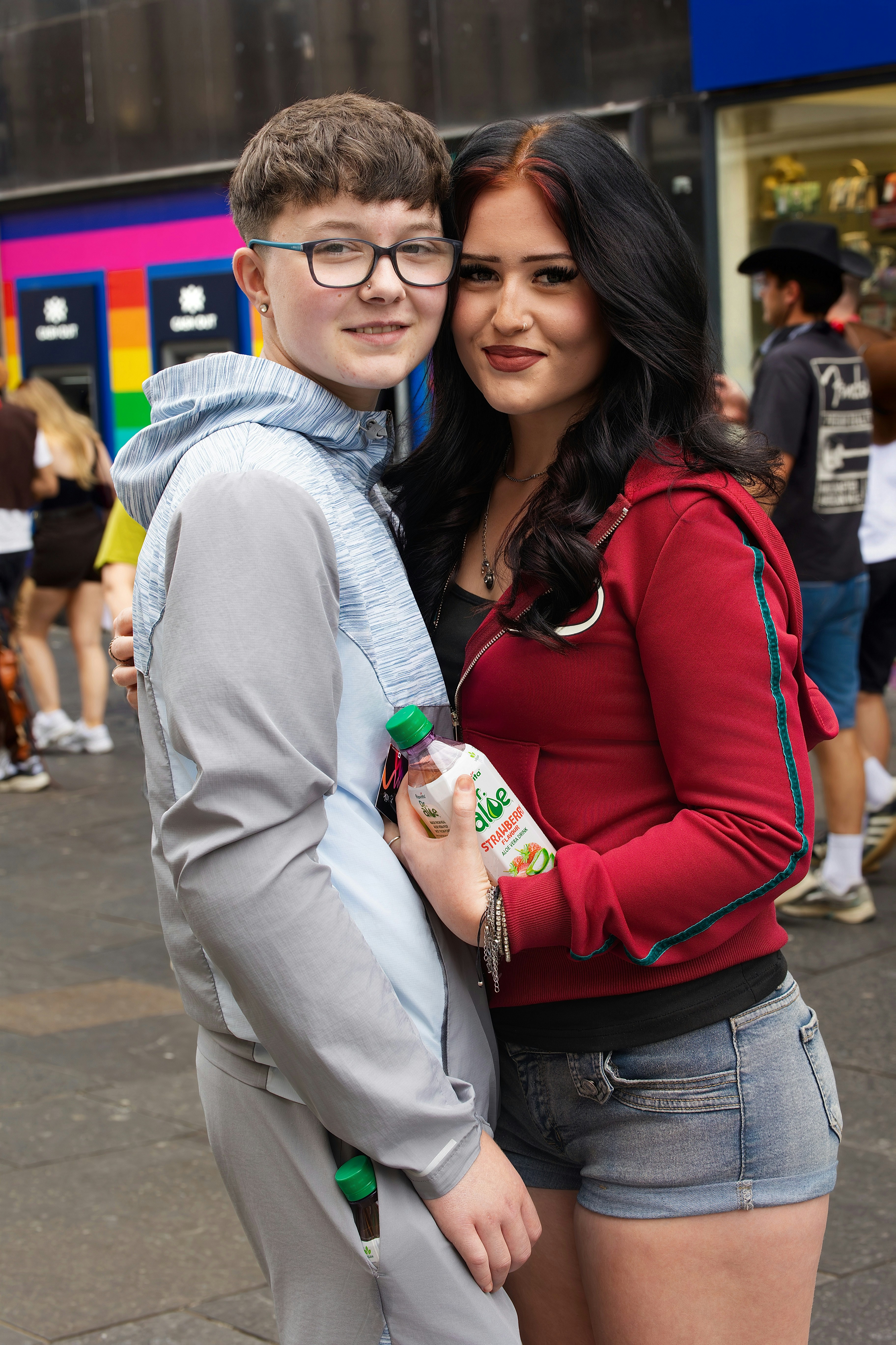 Close Ensemble: Two Friends Share a Moment on a Busy Street