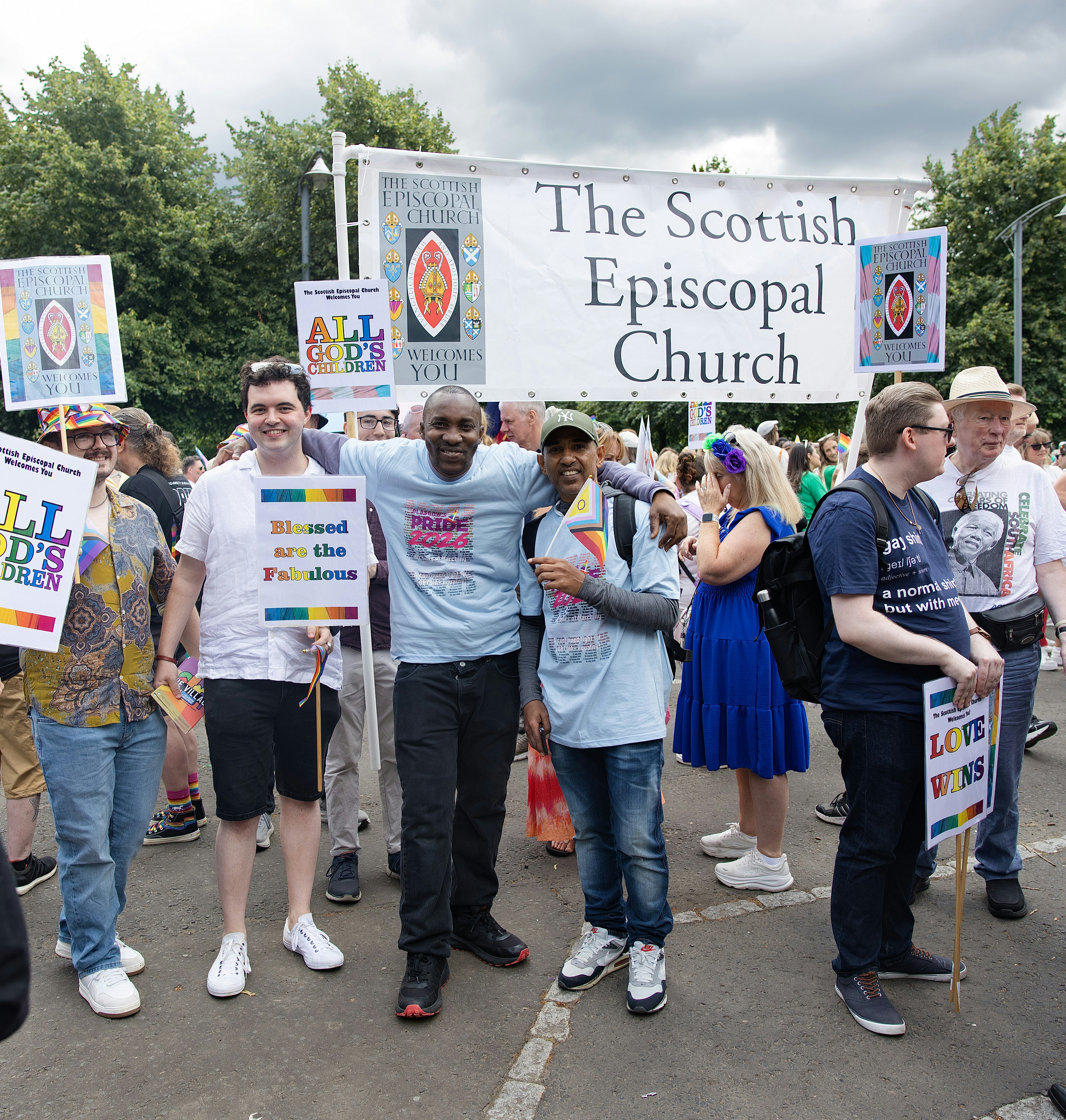 Unity in the Town Square: A Pride of Faces Holding The Scottish Episcopal Church Banner