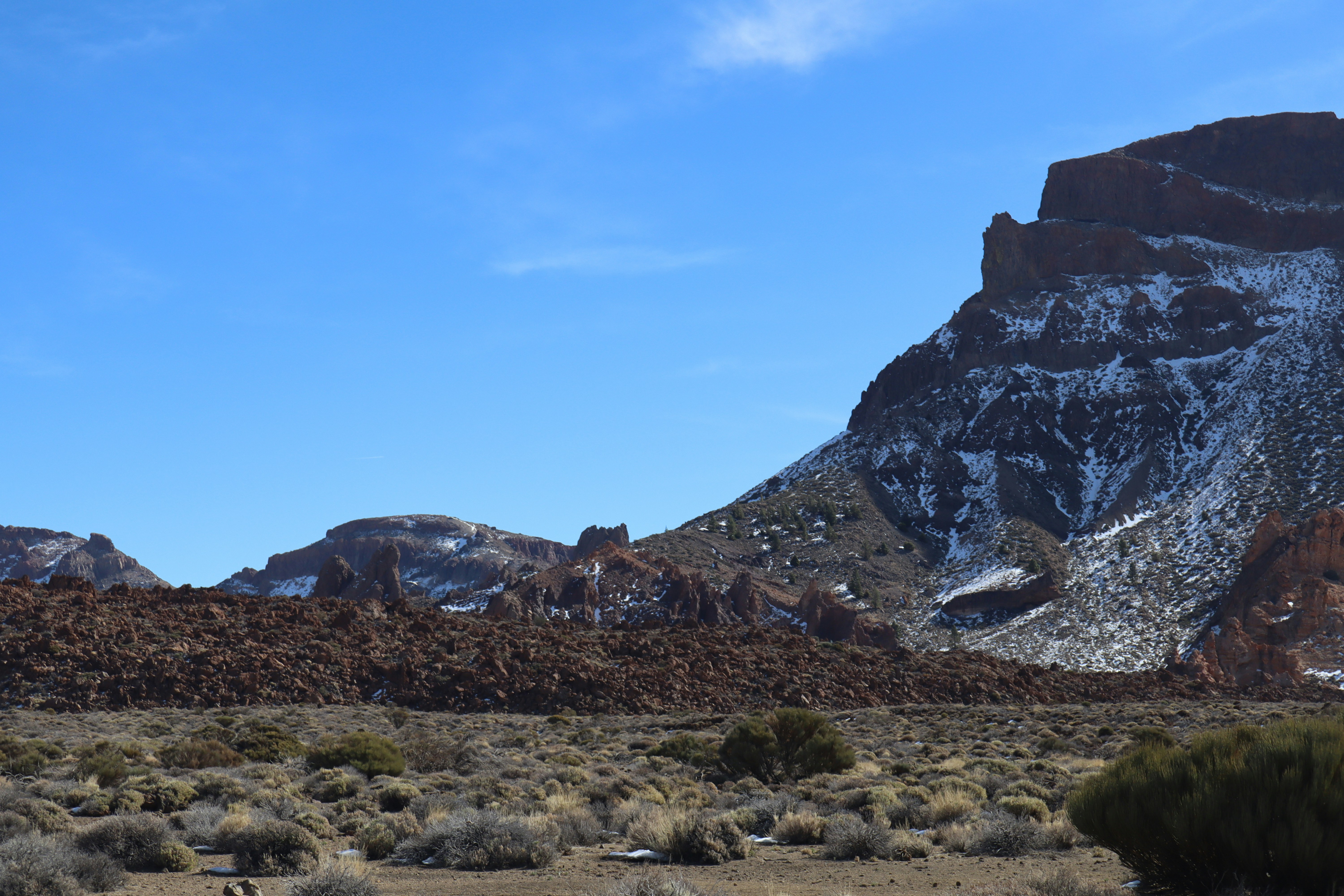 Desert Ridges: Snow-topped Mesa Under Clear Sky