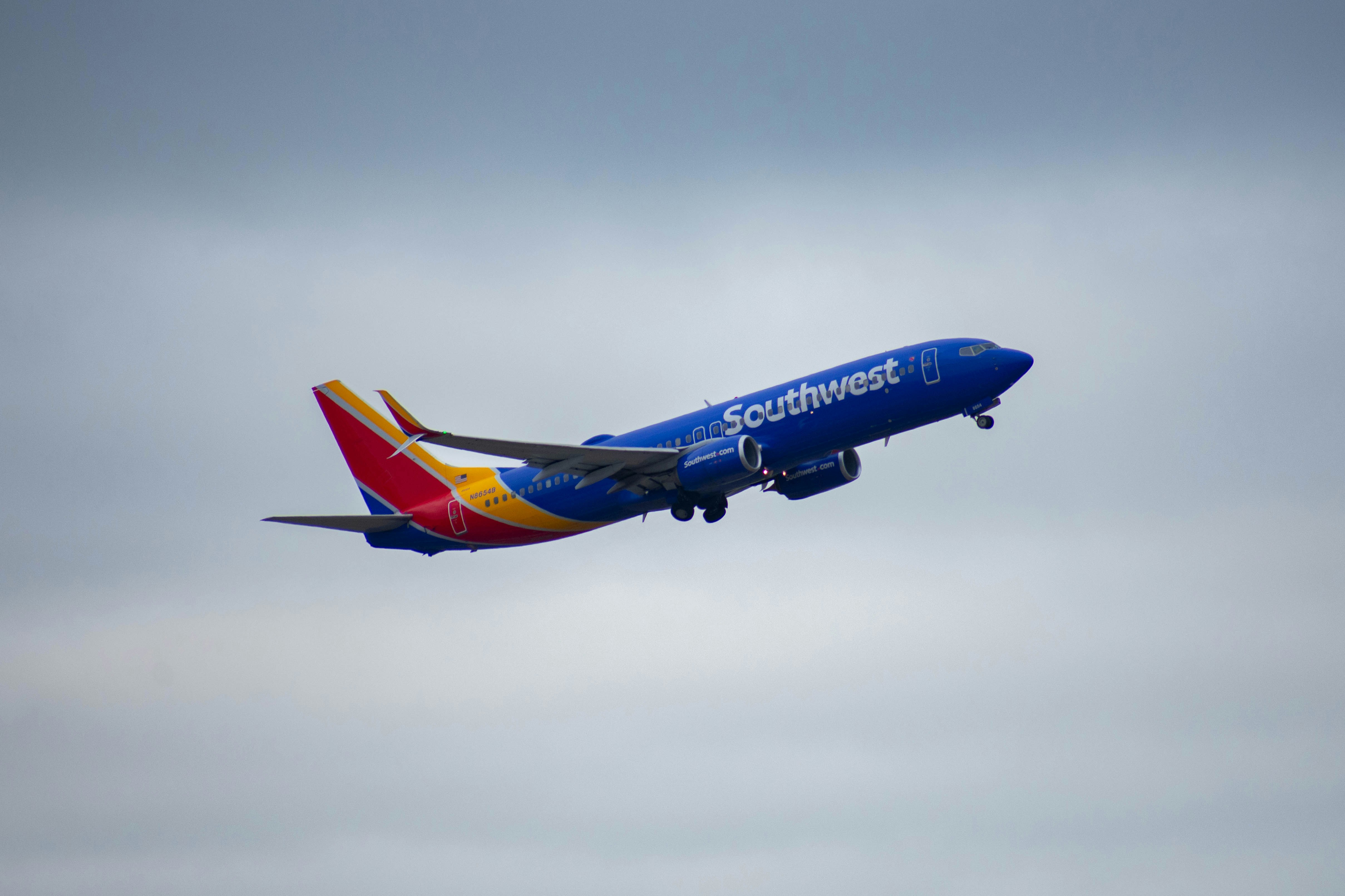 Soaring Blue: Southwest Jet Breaks Through Overcast Skies