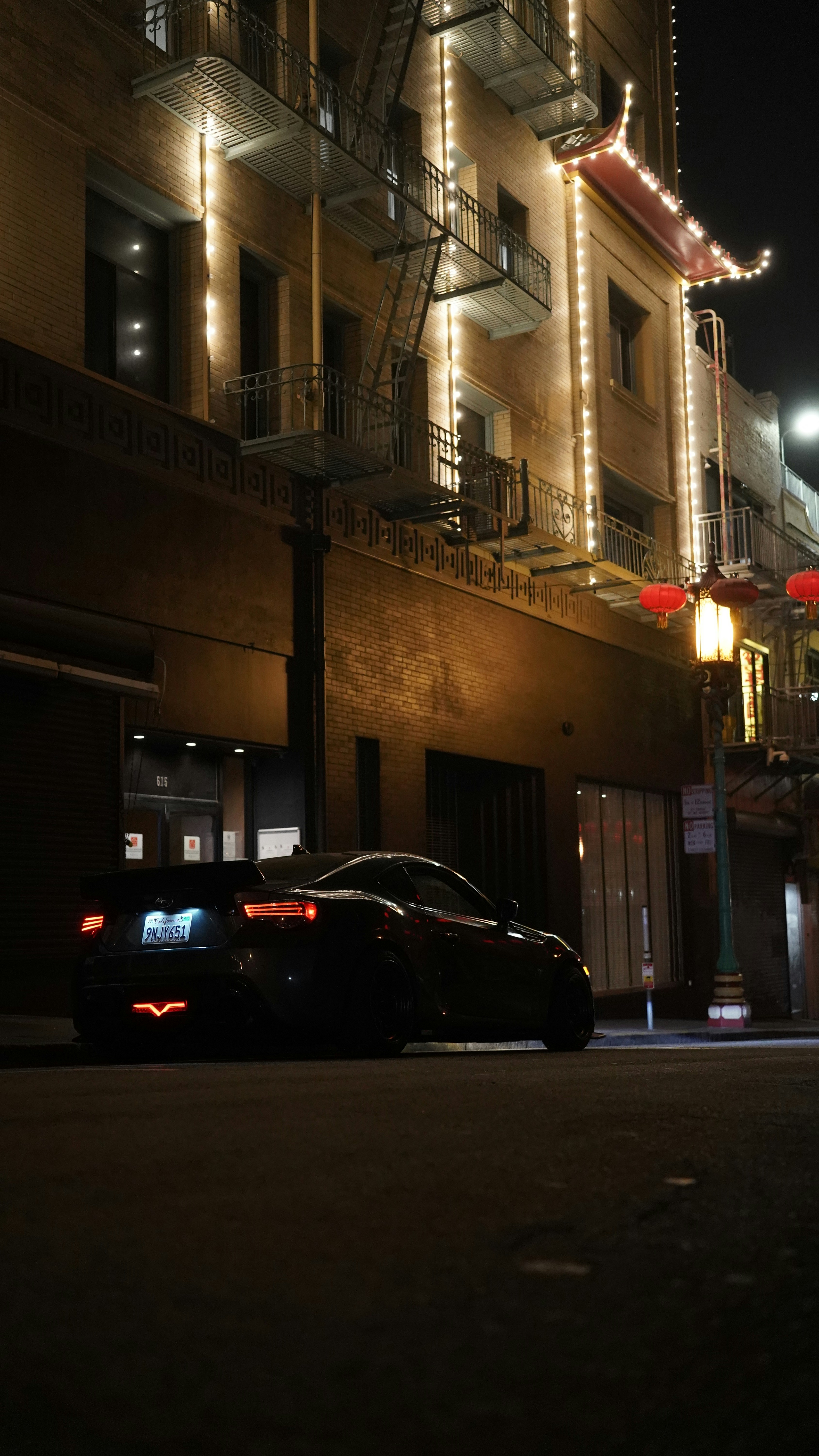 Night Drive Past a Neon-Outlined Street