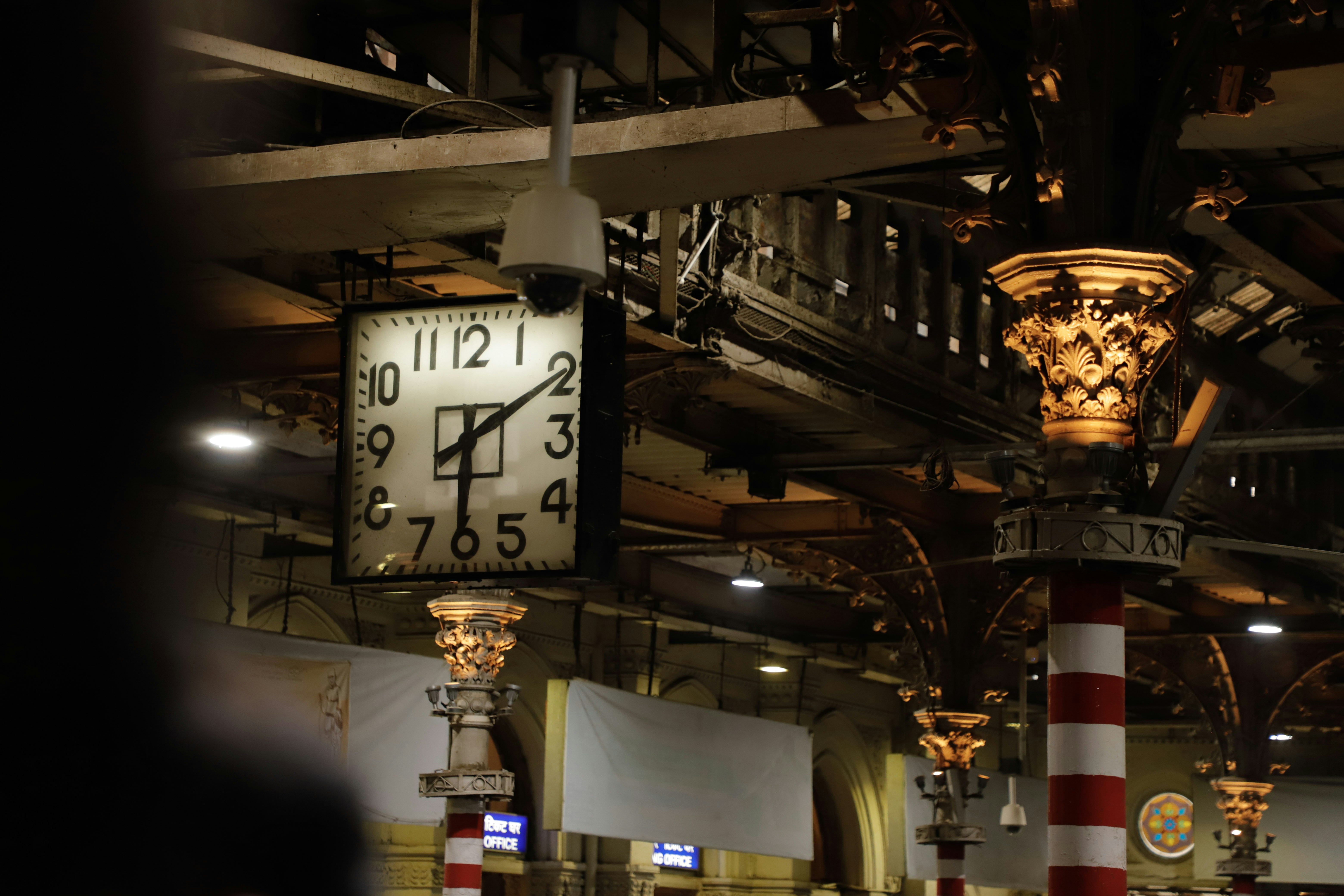 Clock Tower in a Historic Station Hall Framed by Striped Columns