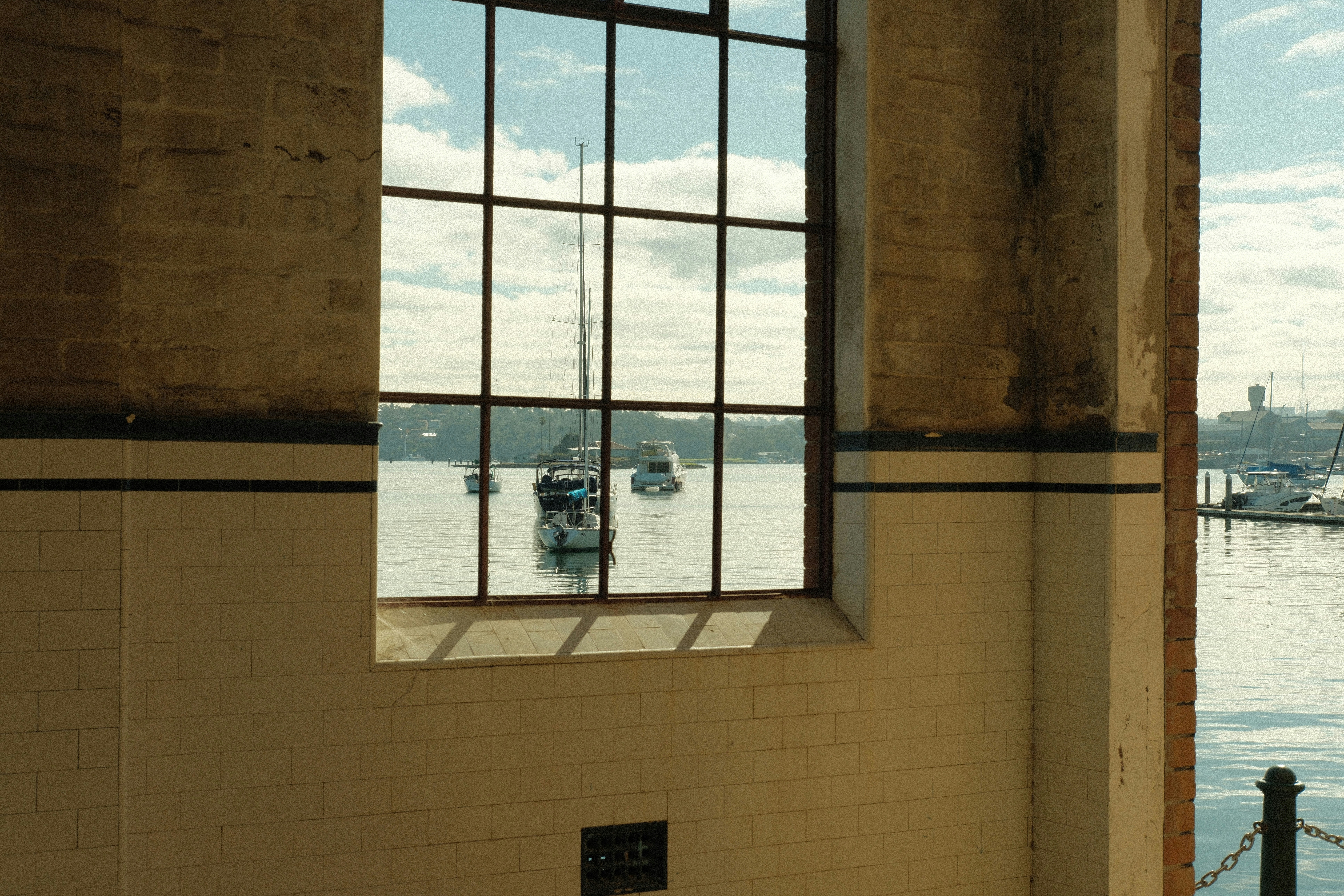 Harbor Window: Boats Framed by Industrial Tile and Brick