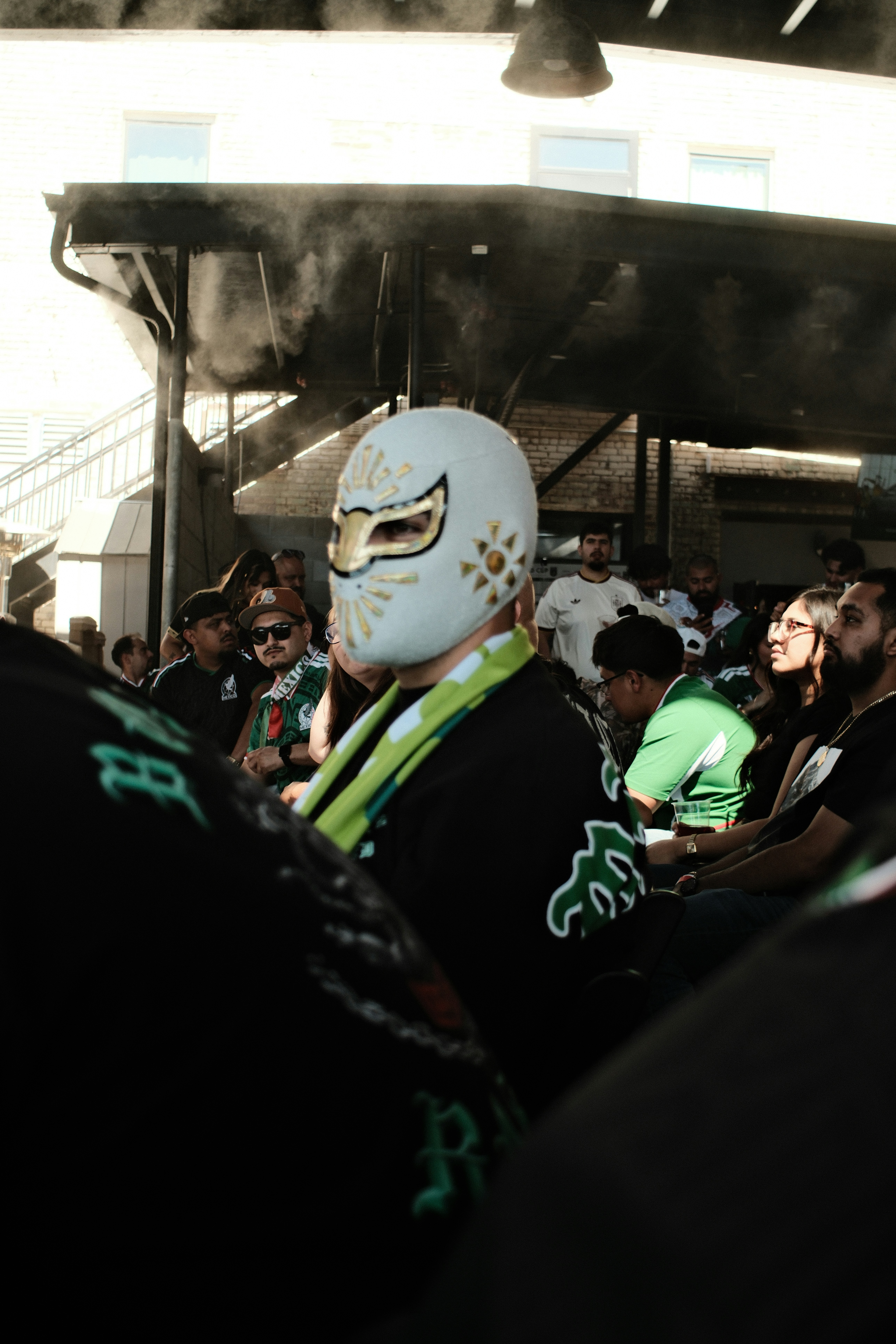 Masked Performer in a Crowd: Quiet Spotlight in a Stadium-esque Corridor