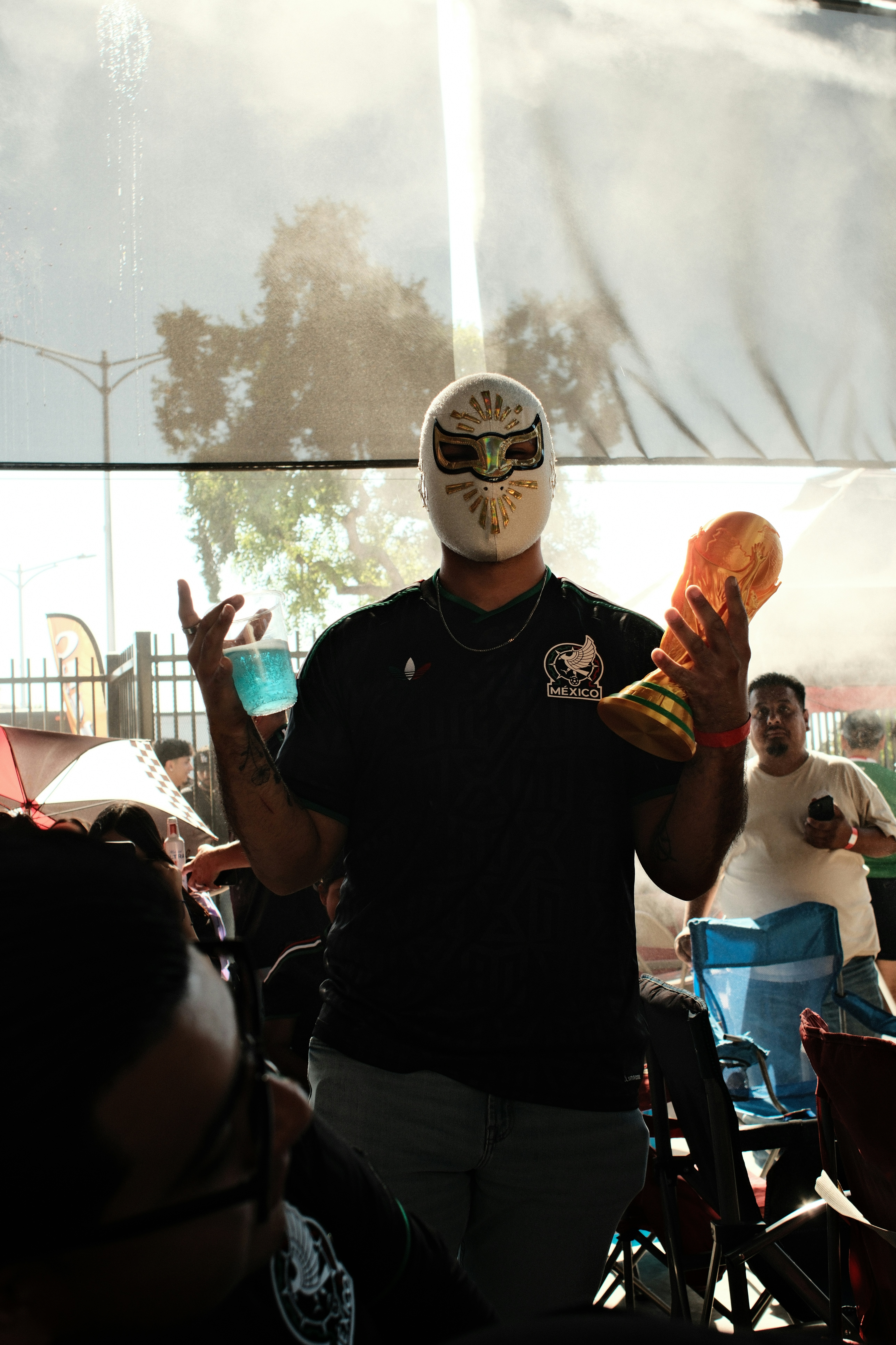 Masked Performer at Center Stage in Sunlit Festival Tent