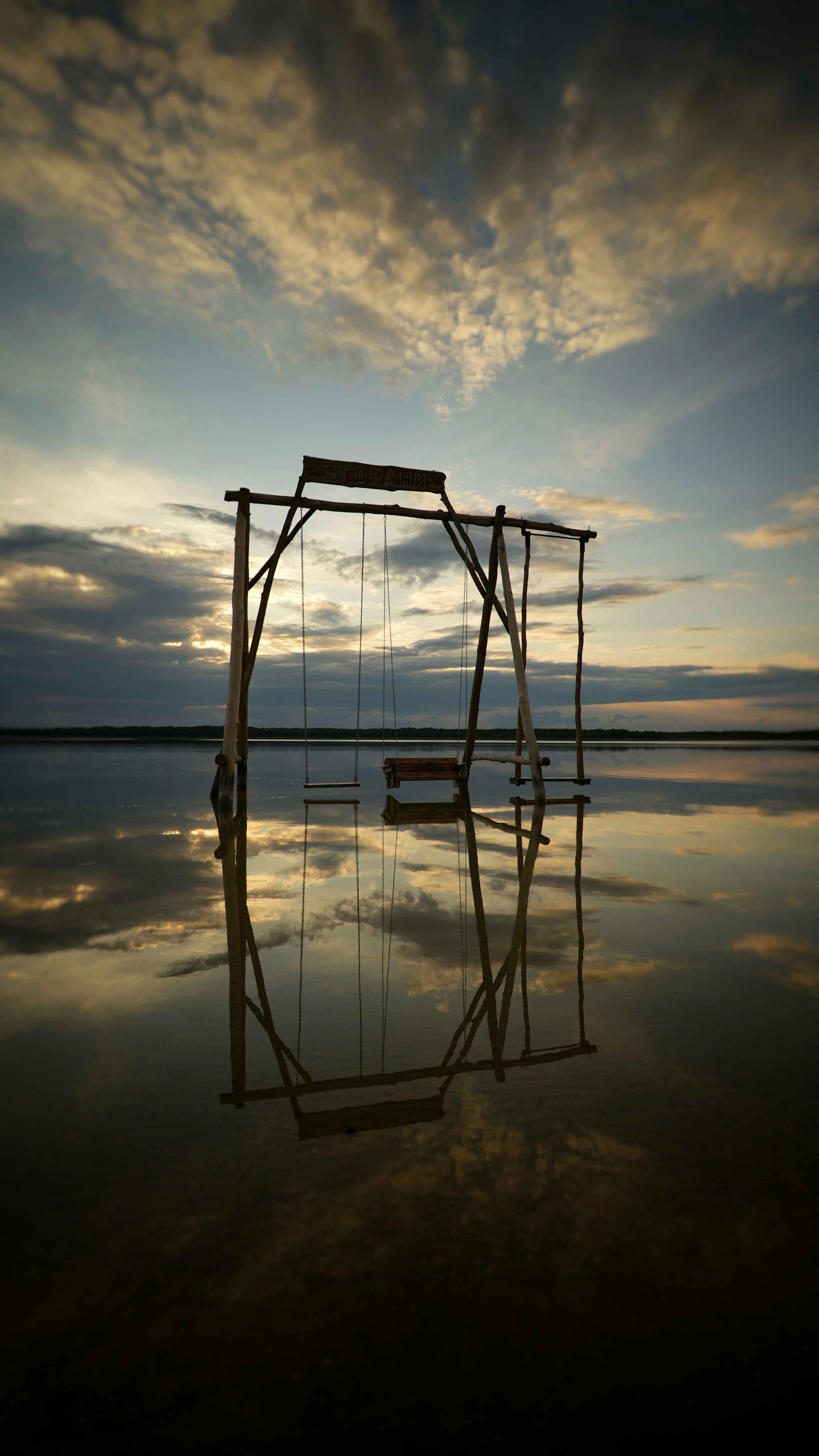 Silent Swing Over the Still Lake at Sunset
