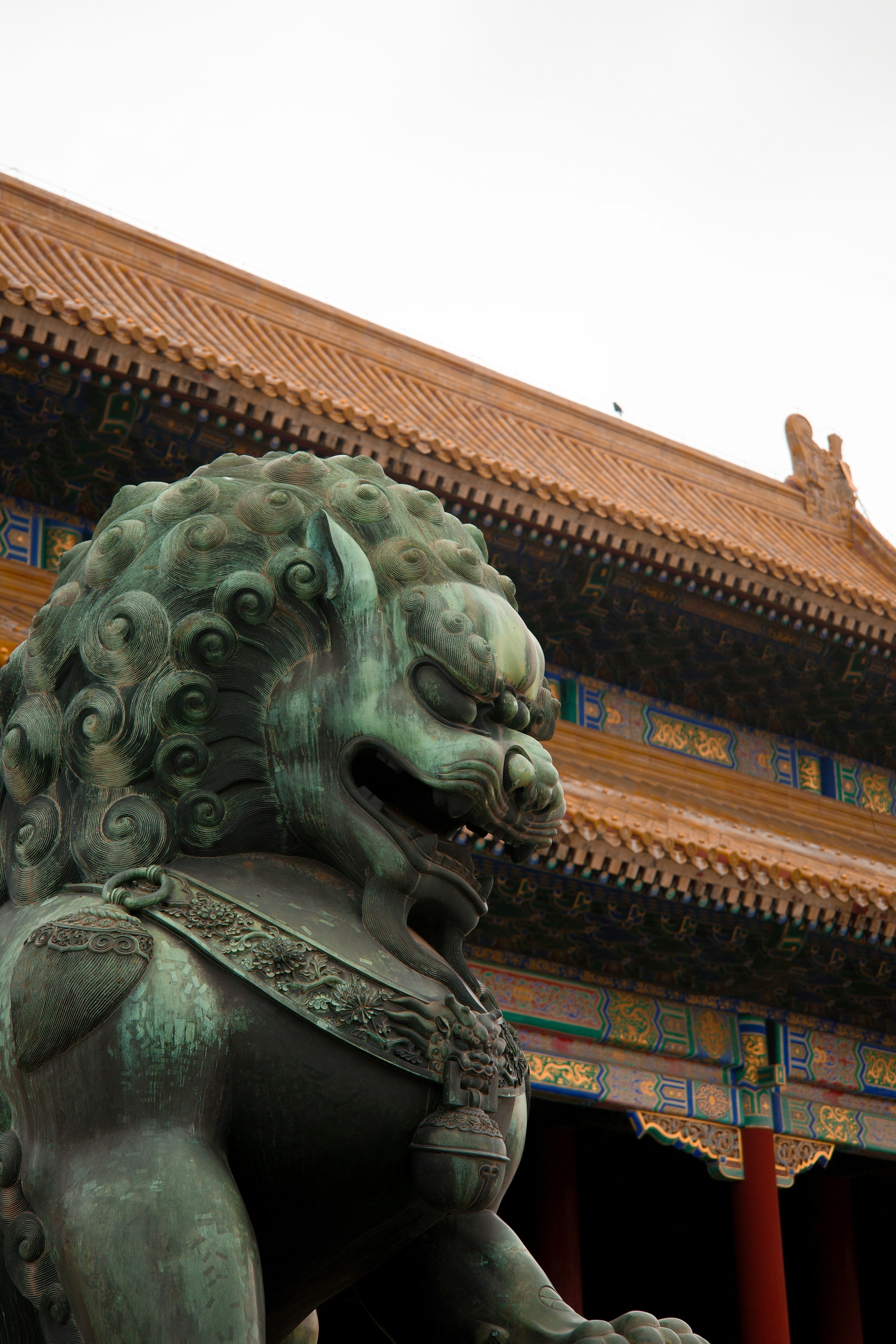 Bronze Guardian: A Dragon-Headed Statue Against an Ornate Temple Facade