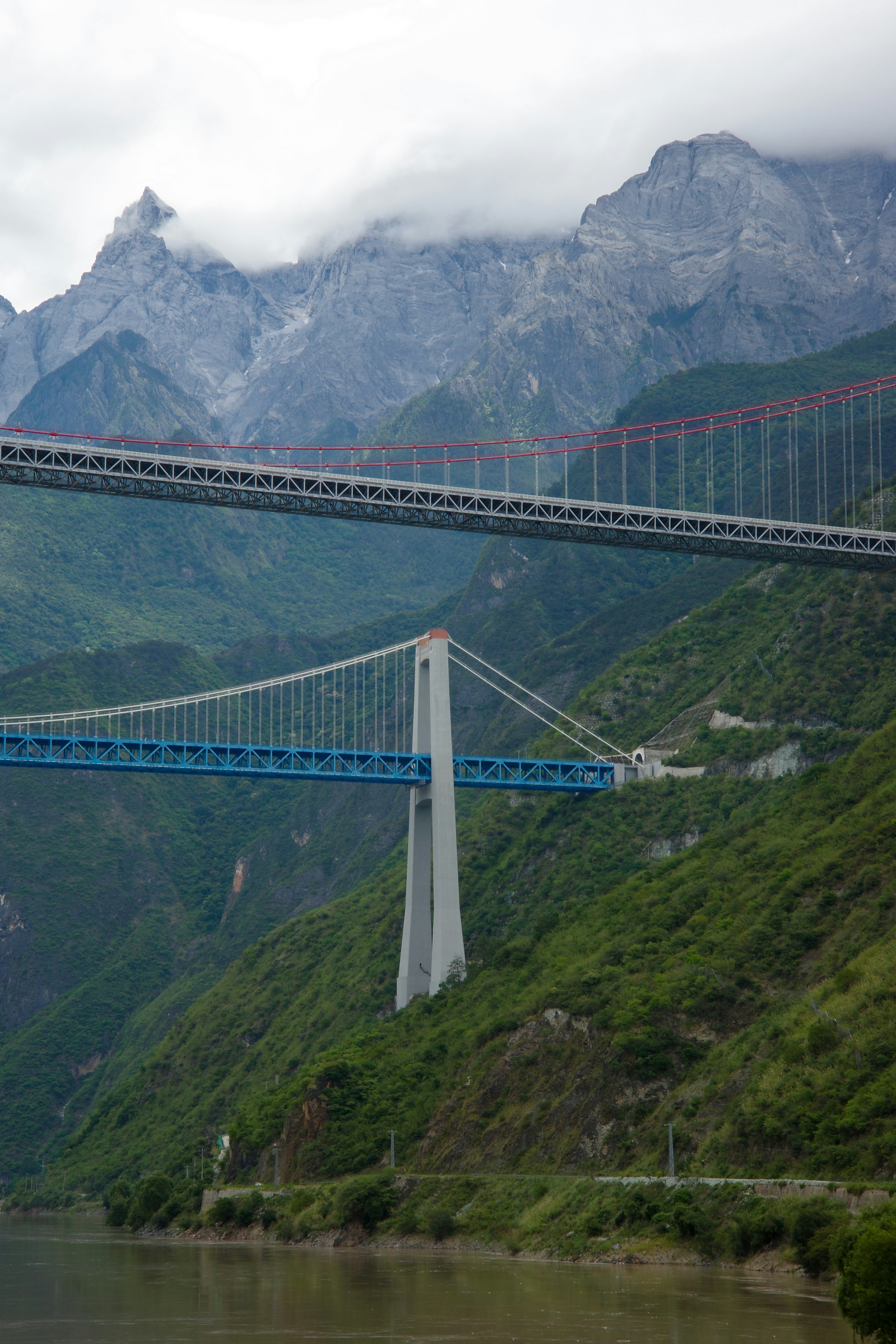 Suspended Between Peaks: A Blue-Highlighted Suspension Span Across a River Gorge