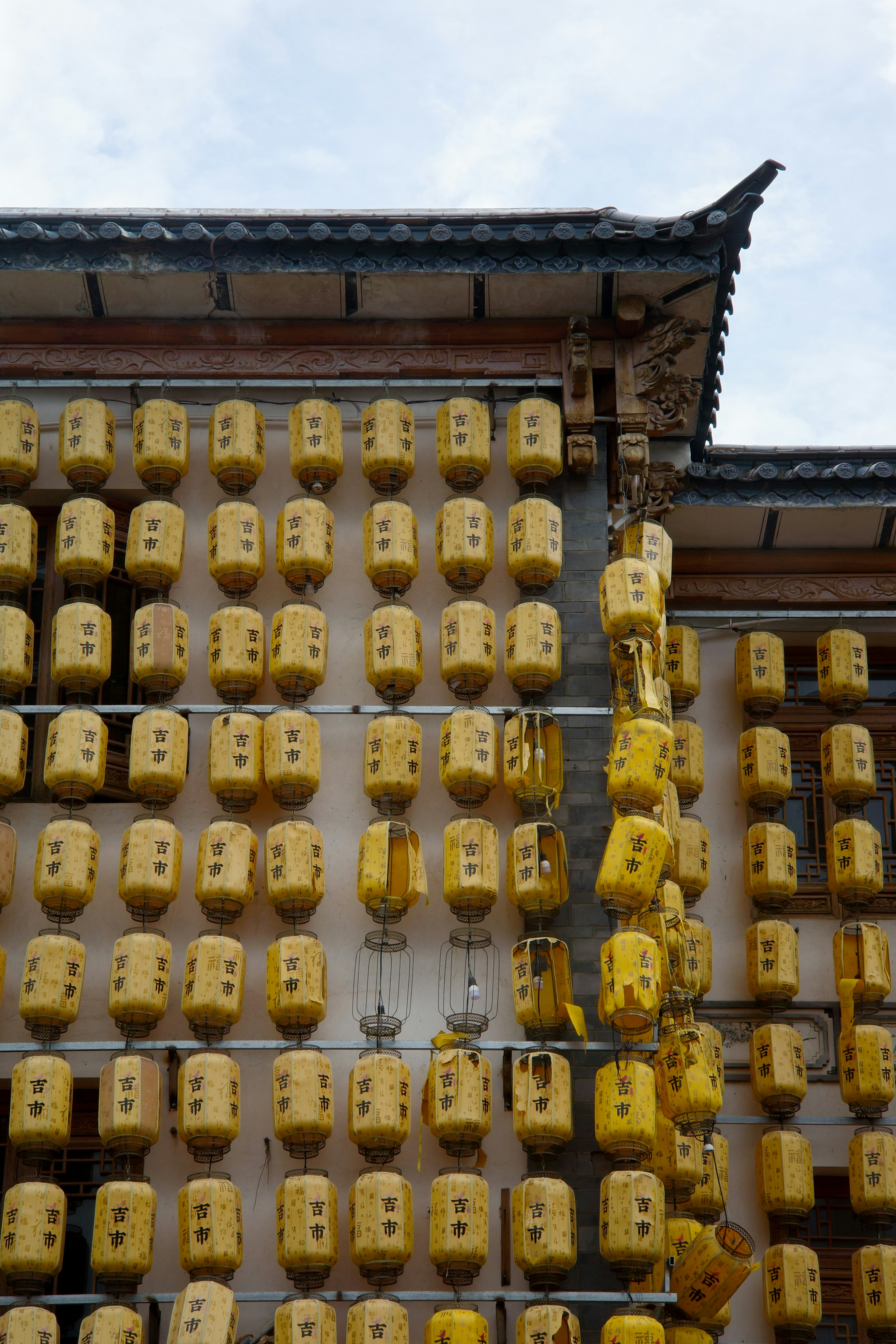 Rows of Yellow Lanterns Adorning a Traditional Temple Facade