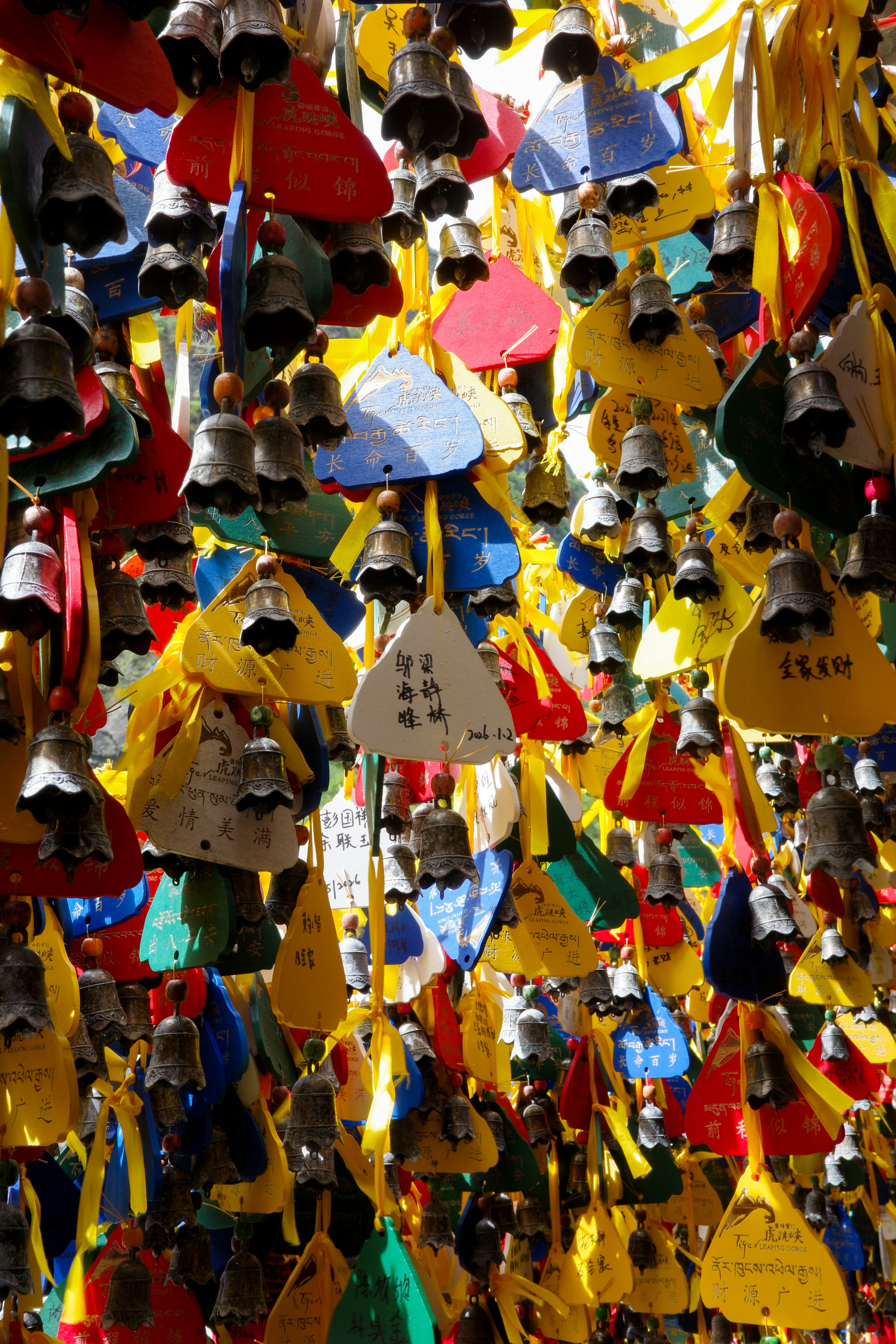 Colorful prayer tags dangling from bells in a crowded shrine