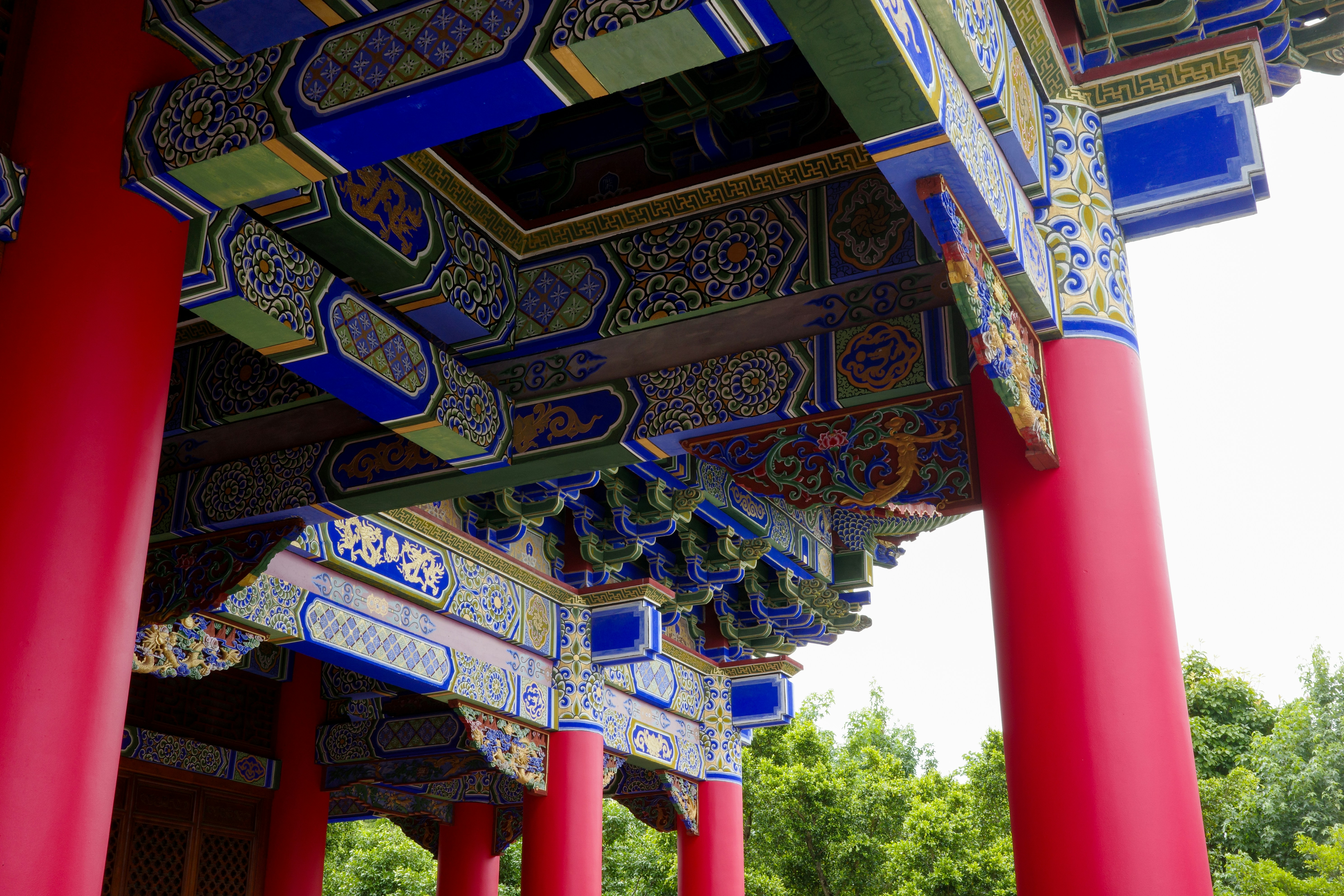 Ornate Pavilion Frieze: Red Columns Framing a Painted Timber Roof