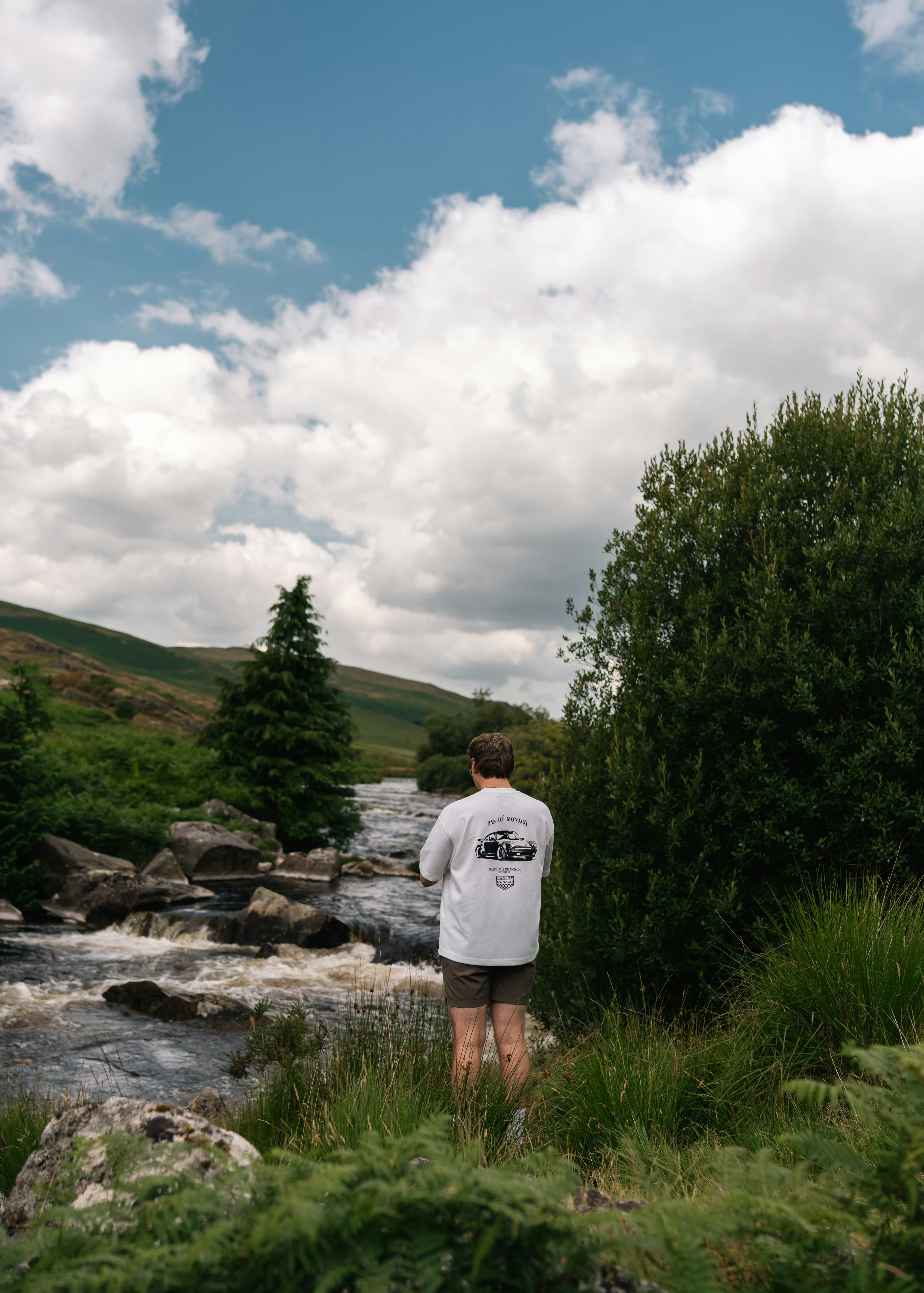 Hiker by the River: Quiet Moment Among Hills