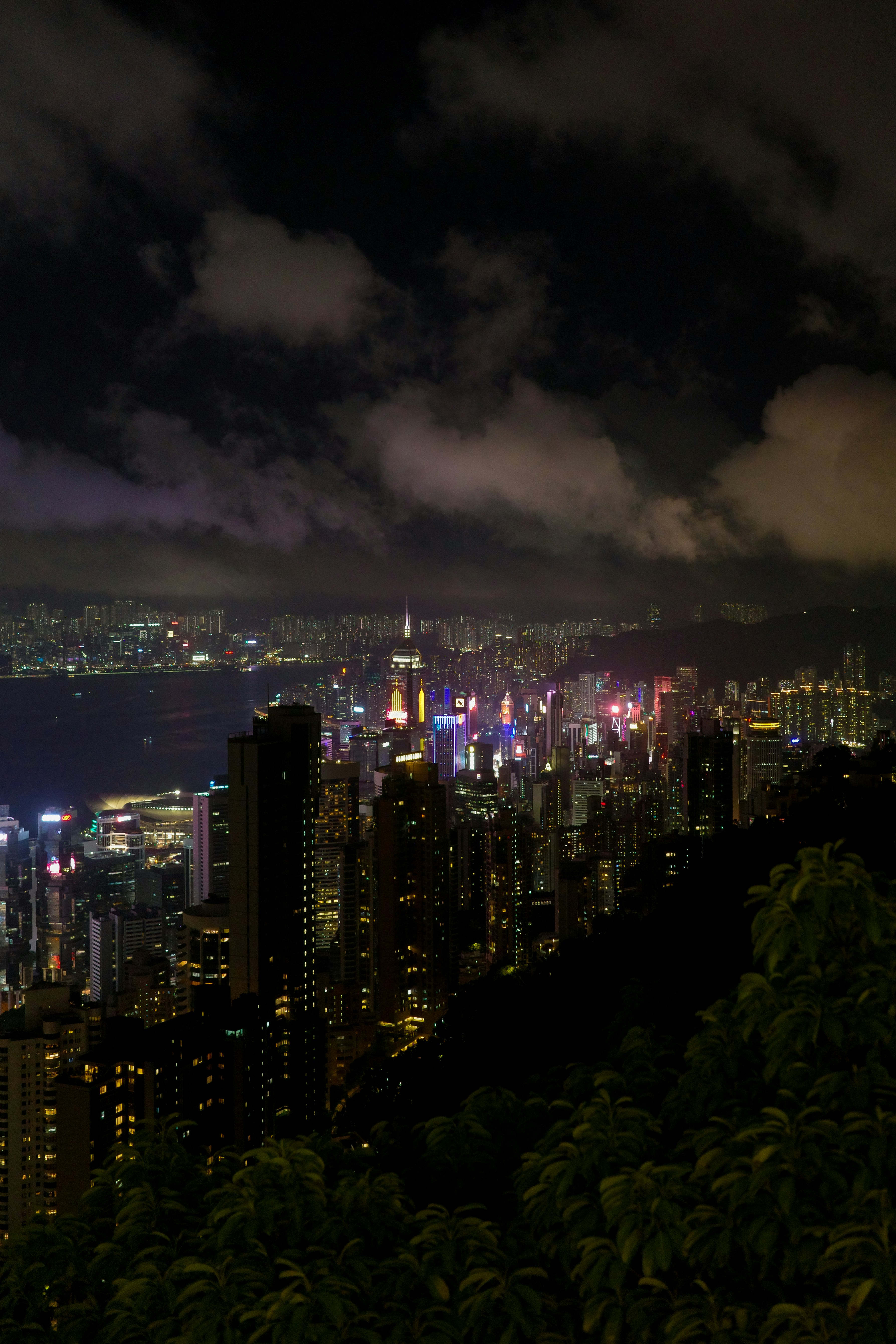 Neon Harbor: Cityscape Below a Clouded Night