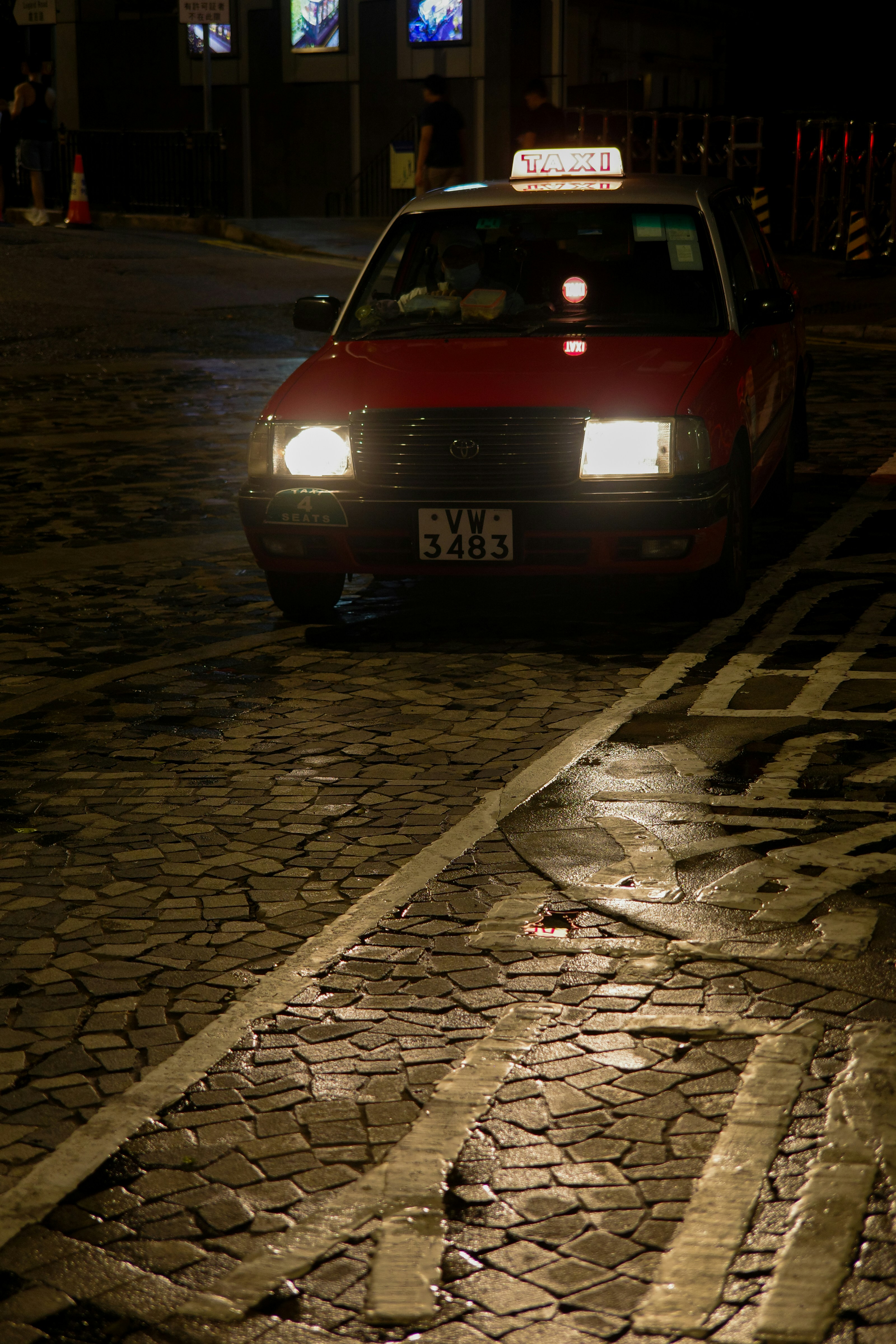 Midnight Taxi Glare: A Red Cab at the Edge of the Street