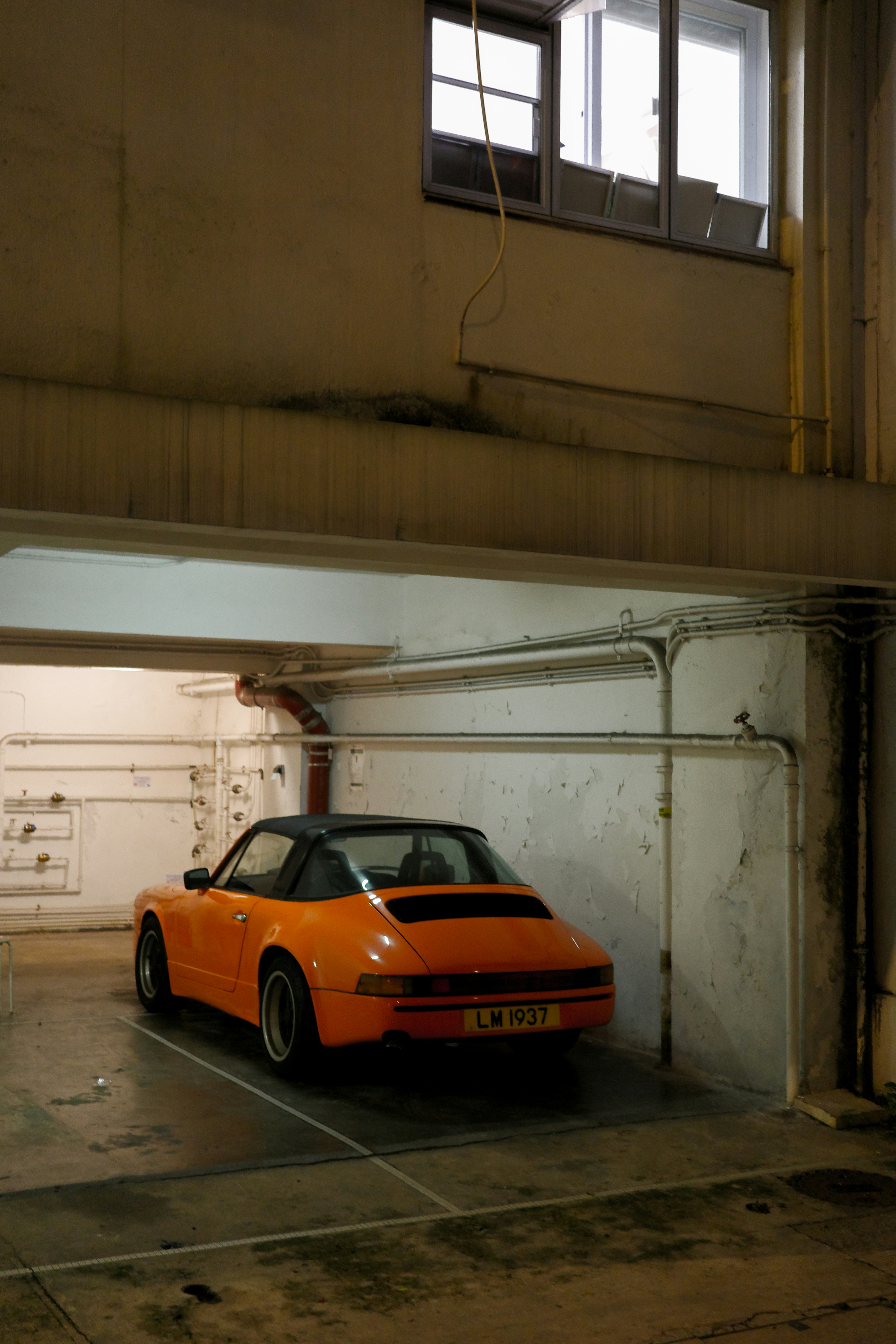 Orange Porsche in a dim basement garage
