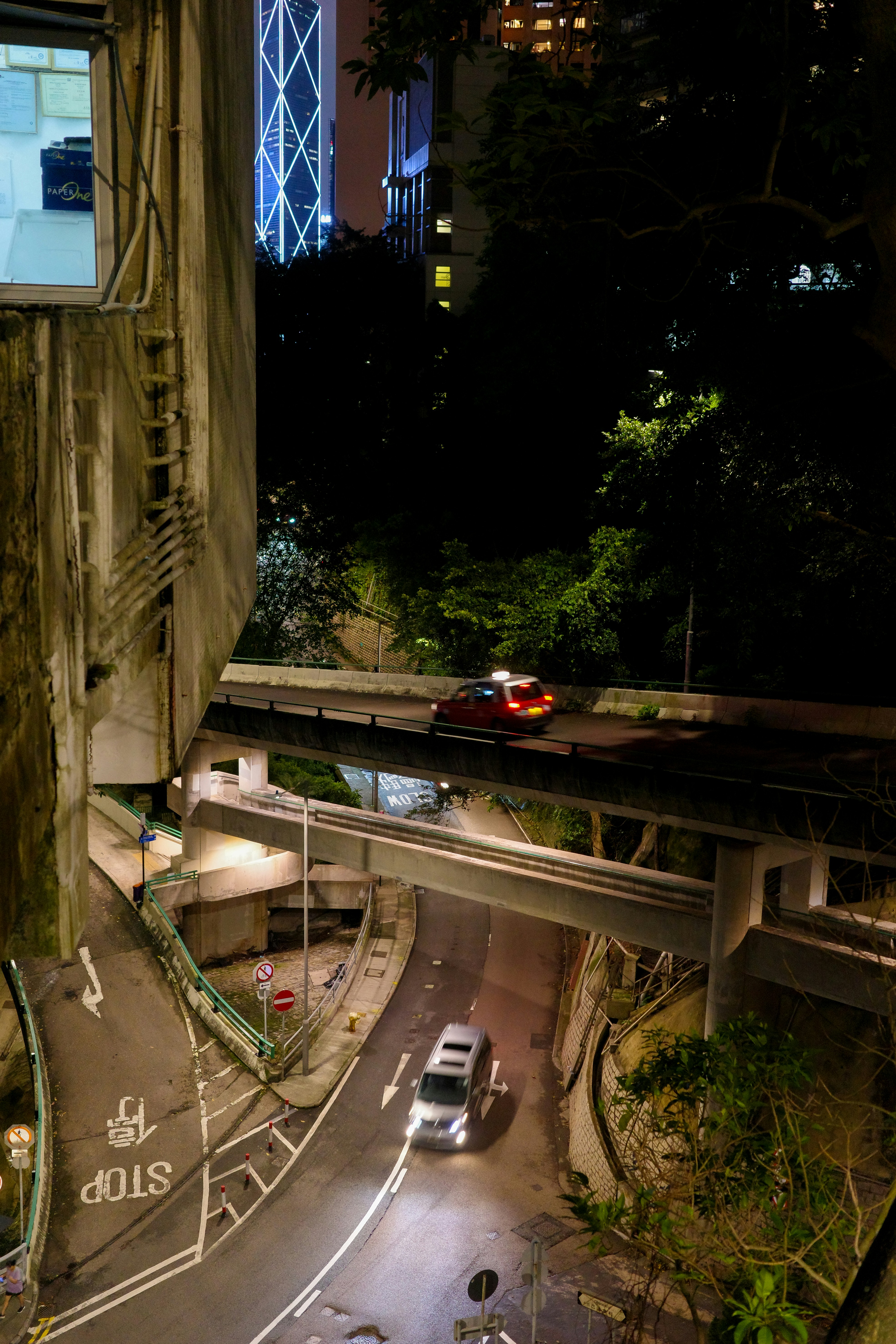 Multilevel Night Drive Through a Neon-Illuminated Urban Spine