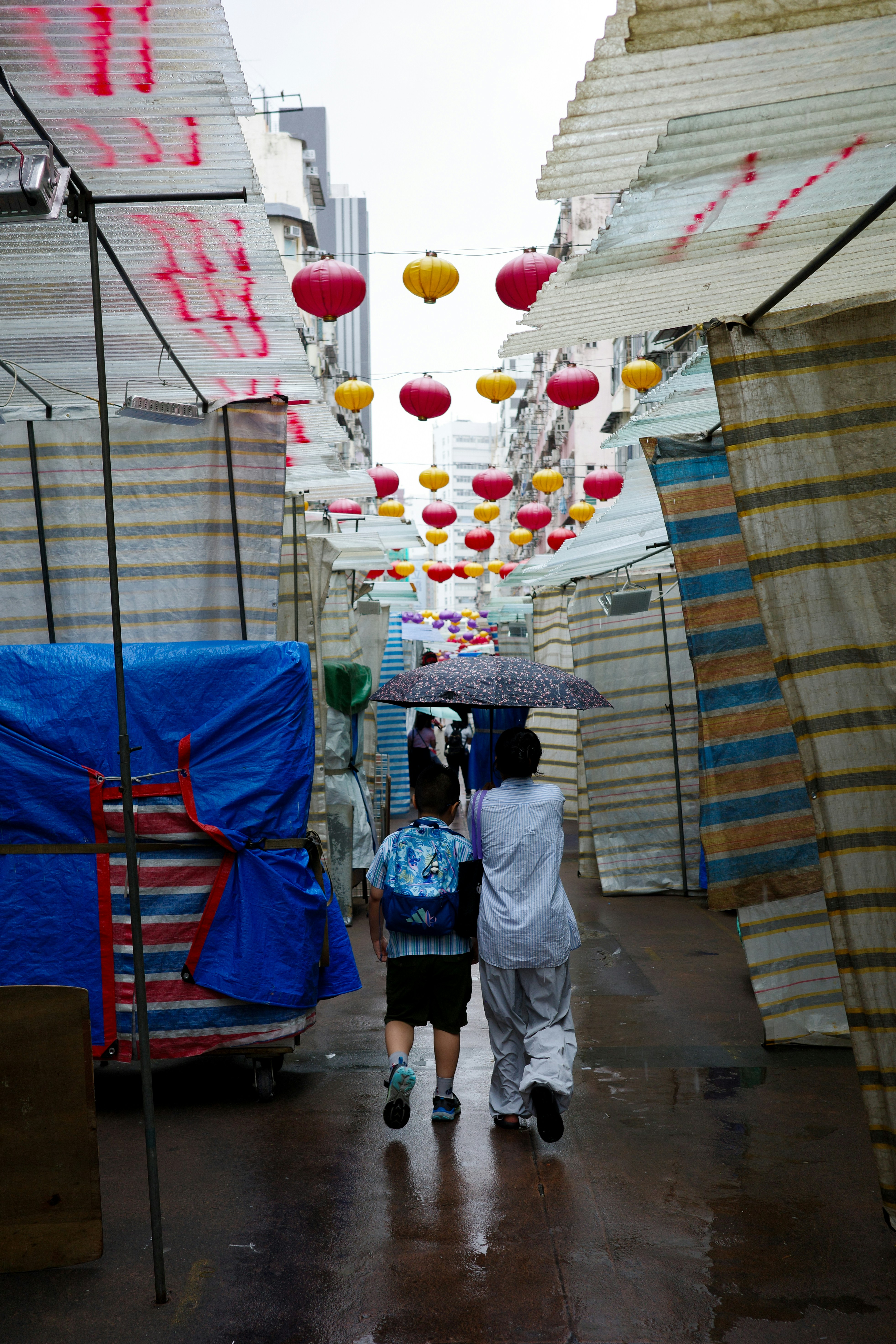 Street Lanterns Lead the Way Under a Rainy Market Canopy