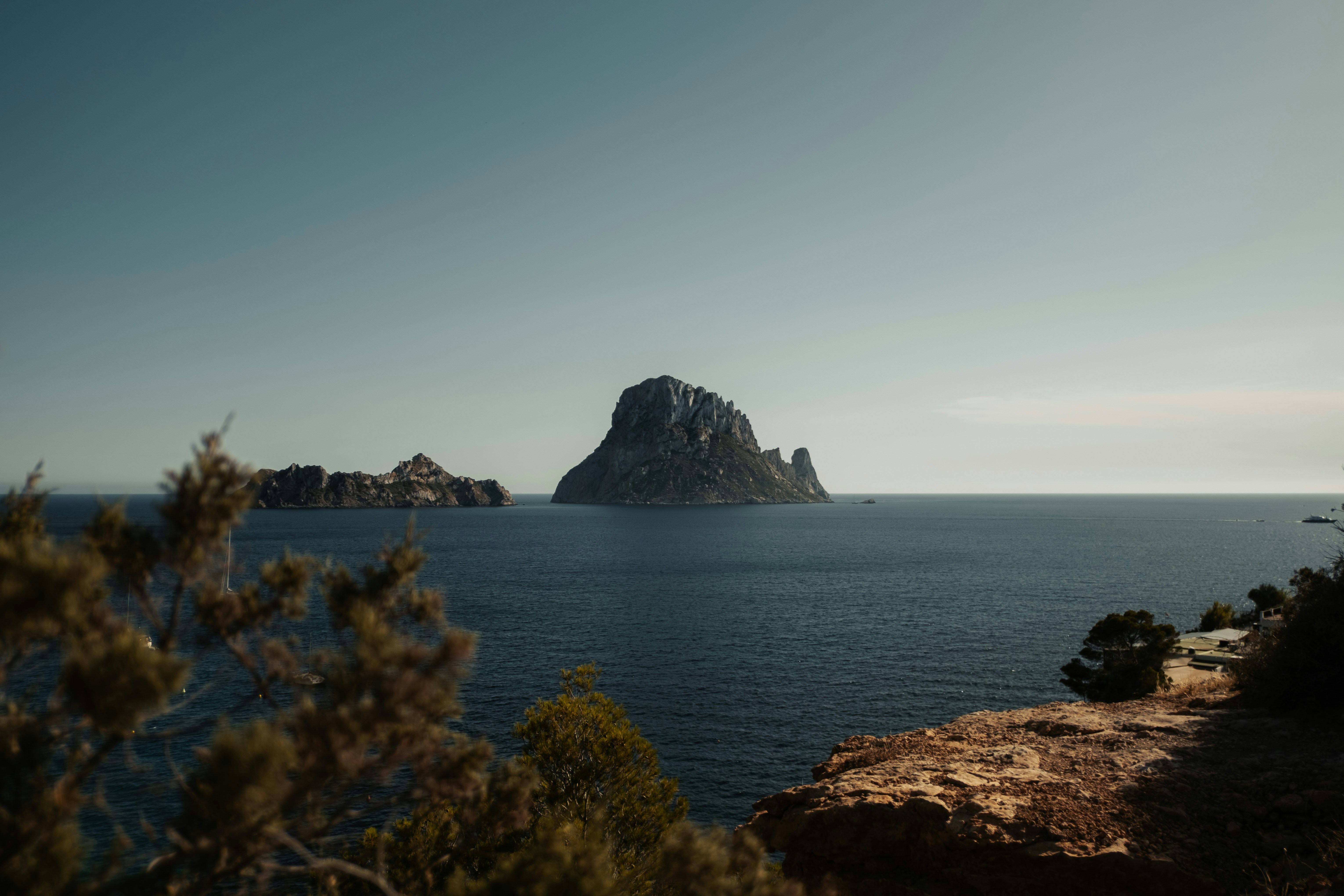 Isolated Sentinel: A lone rocky island rising from a calm blue sea