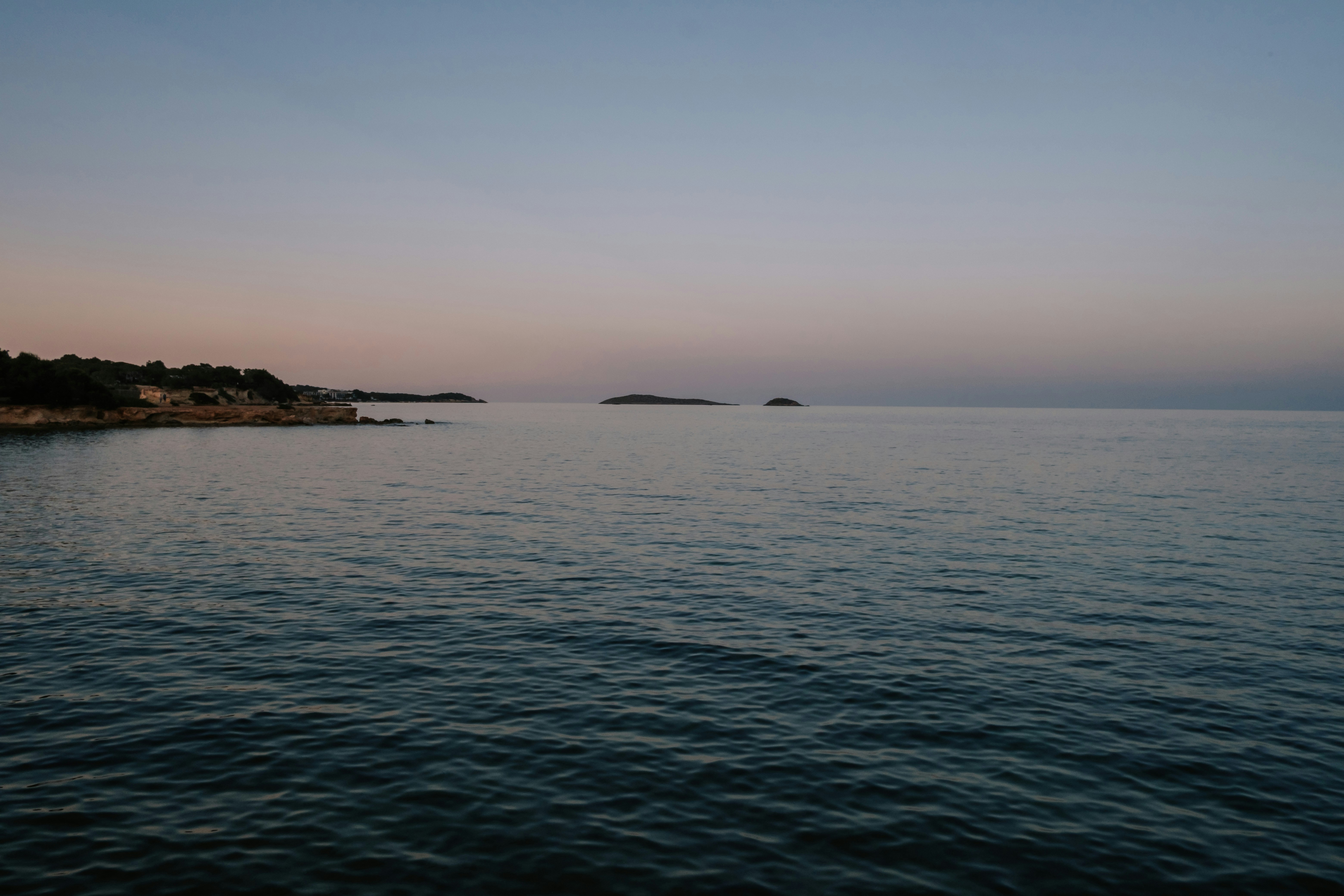 Horizon Calm: Distant Rocks on a Quiet Sea