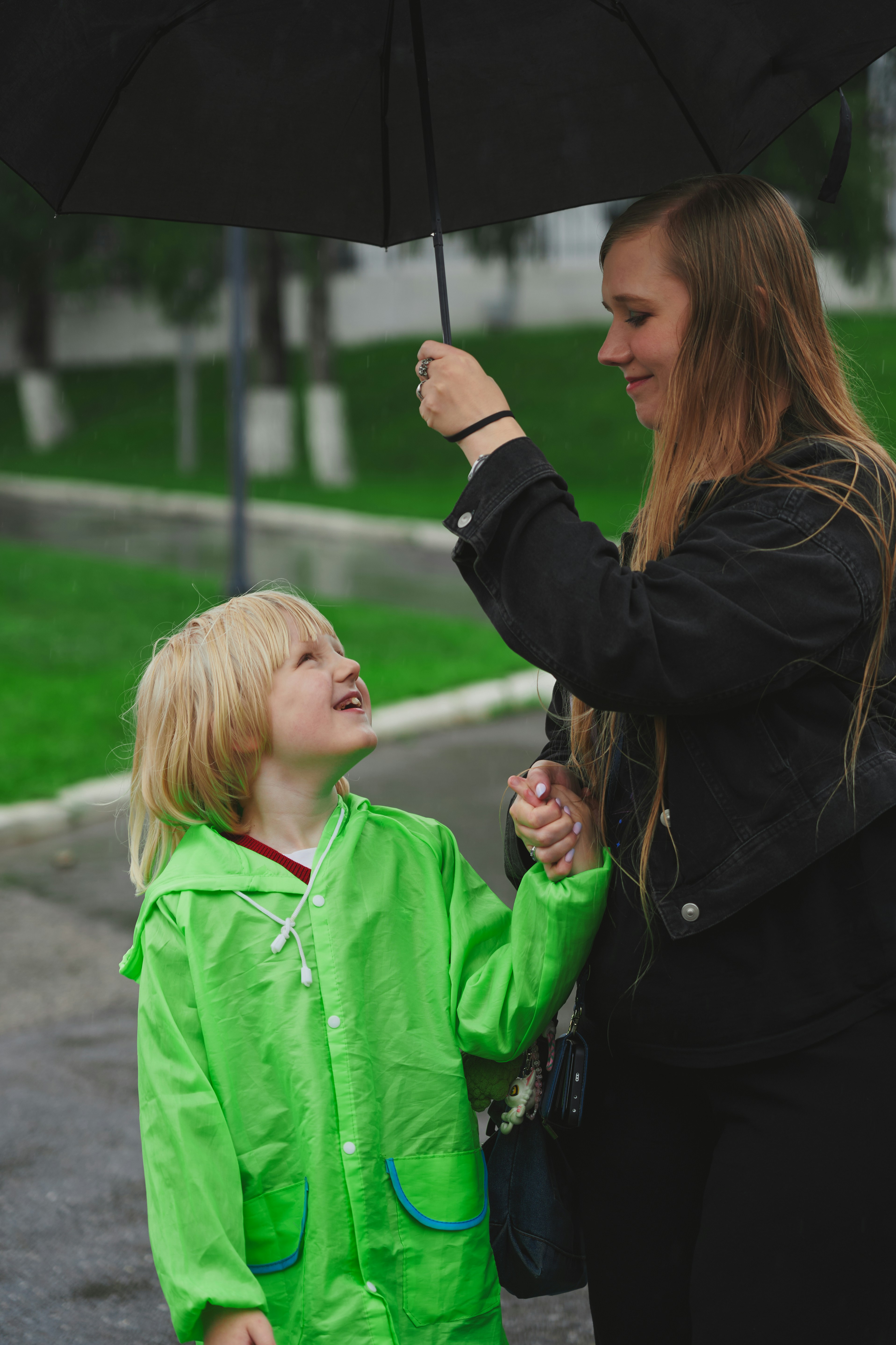 Umbrella Exchange: A Mother's Gently Shared Moment under Rainy Skies