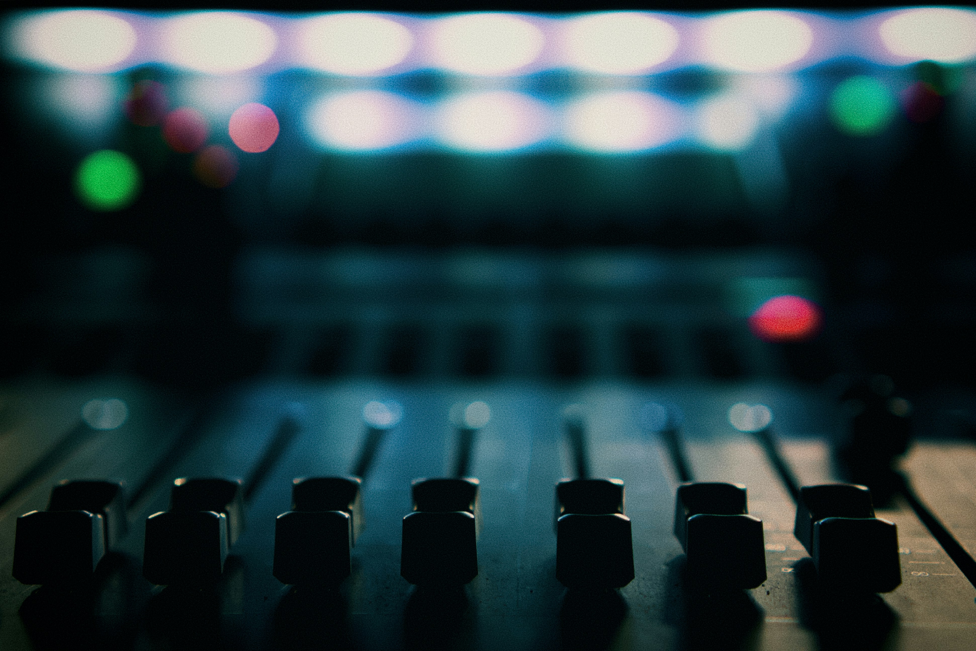 Muted Neon Rhythm: Backlit Knobs in a Dim Studio
