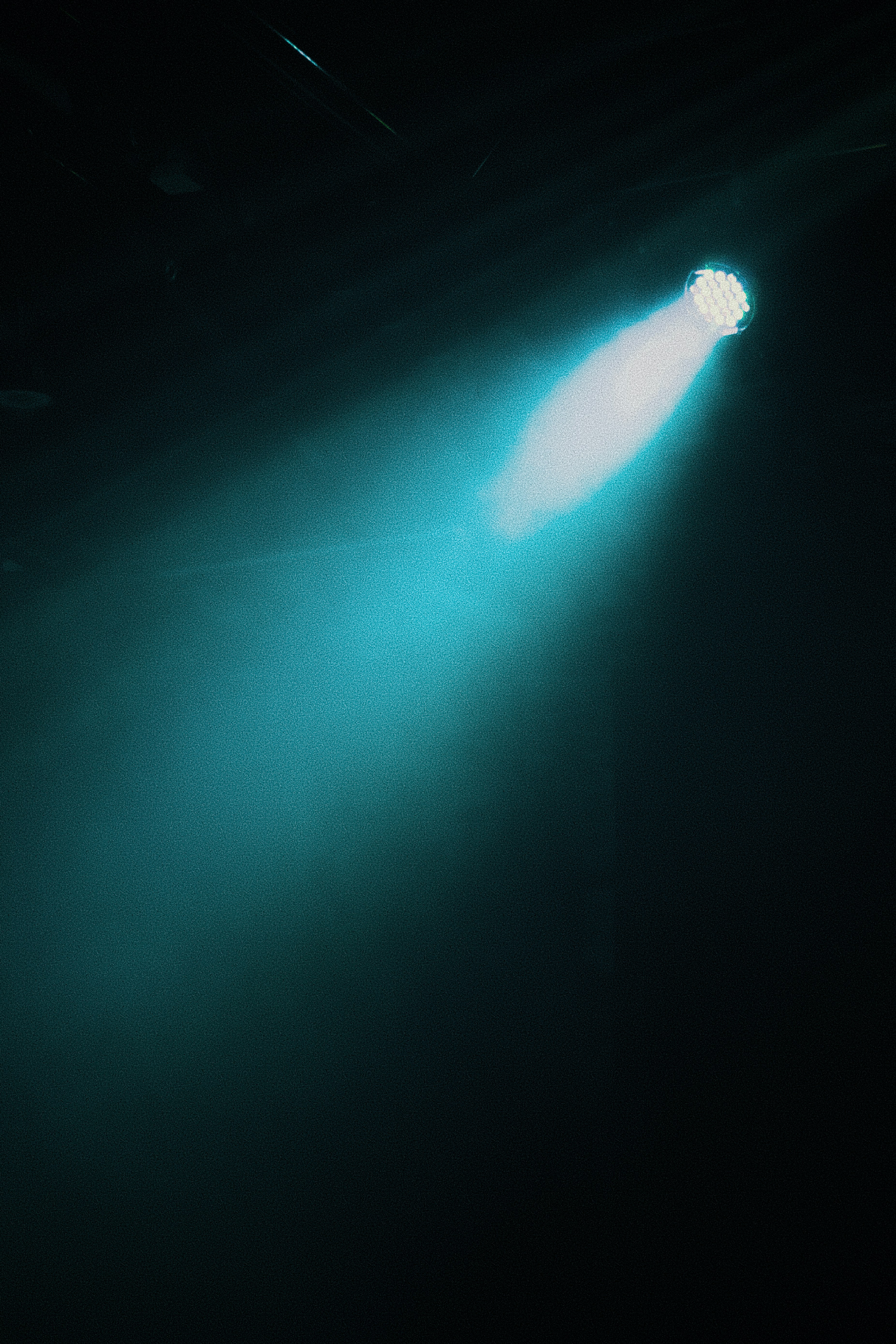 Azure Spotlight Cuts Through Darkness on a Quiet Stage