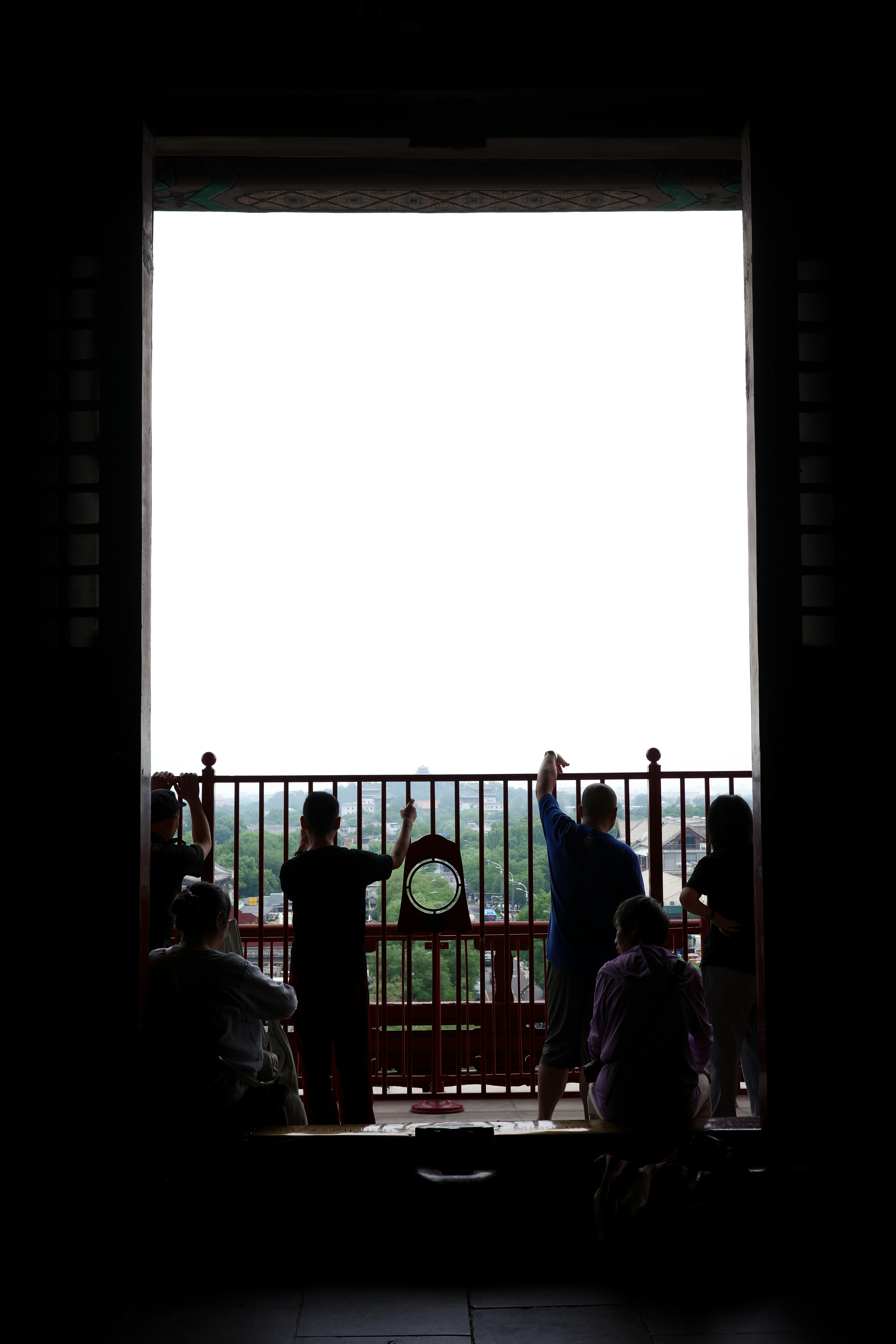 Balcony Viewpoint: Visitors Shadowed by the Gate to a Distant Cityscape