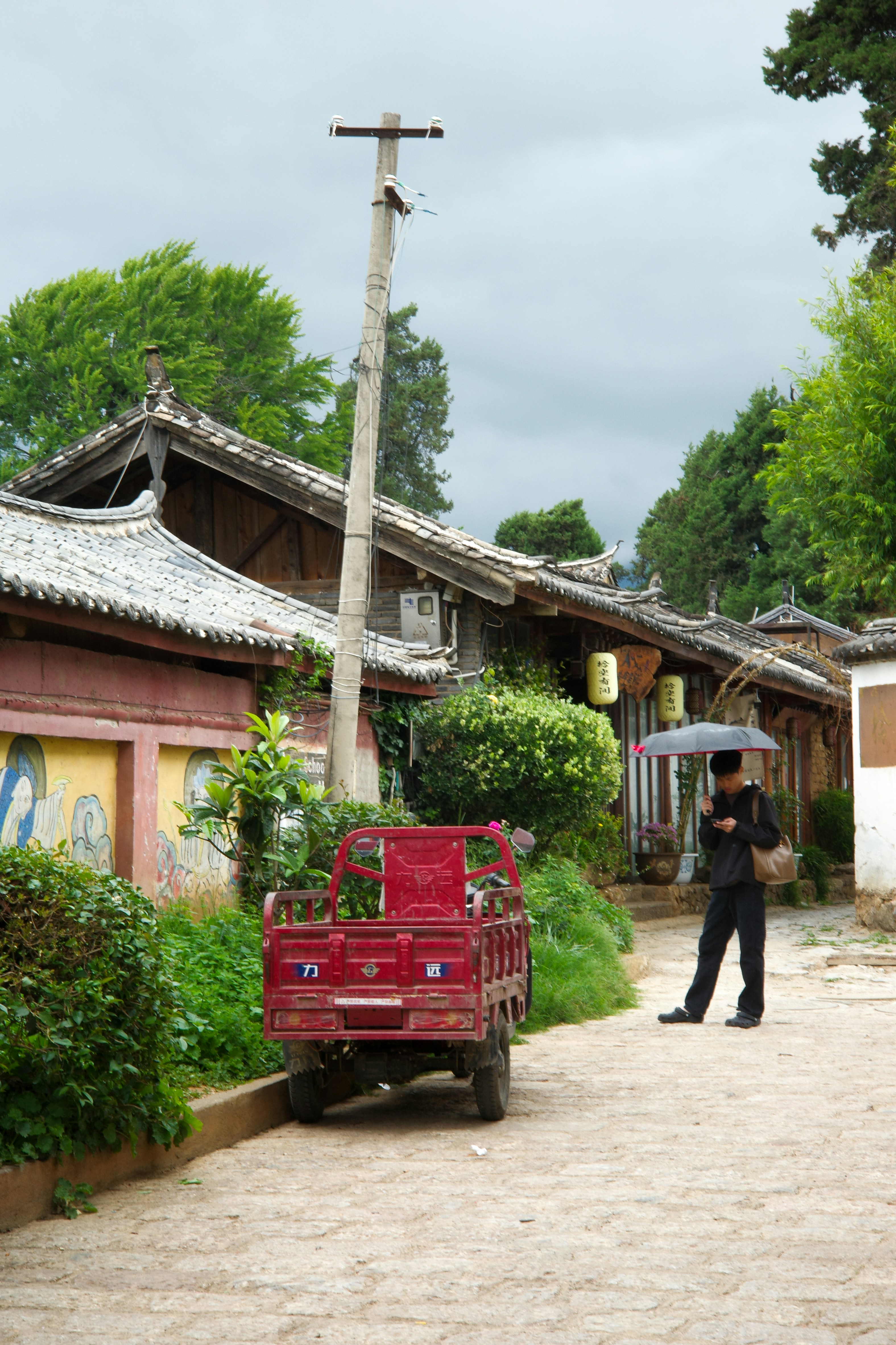 Red Cart, Quiet Alley: Traveler in a Lantern-Lined Village